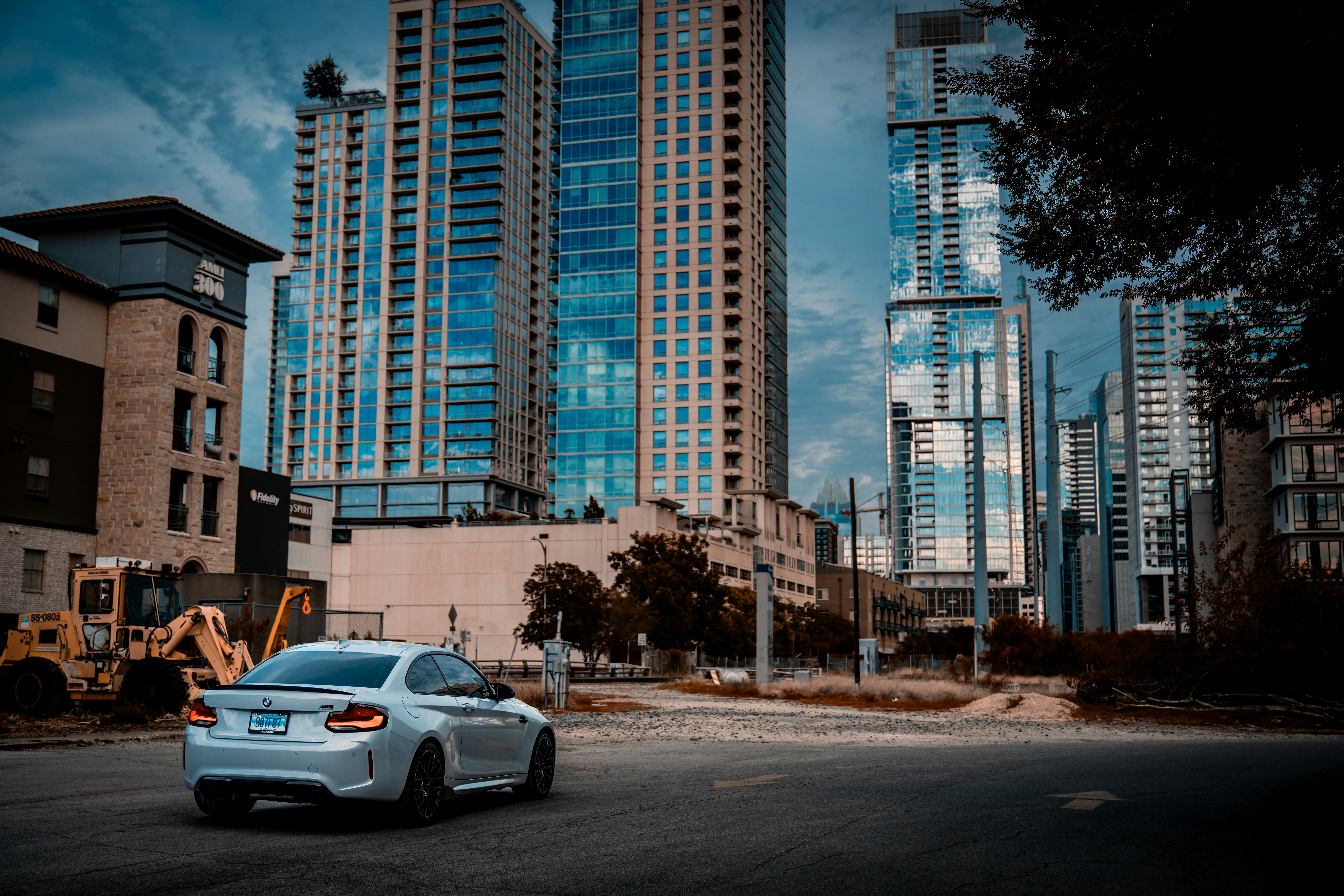 Urban Boulevard Prelude: Silver Coupe Beneath Skyscrapers