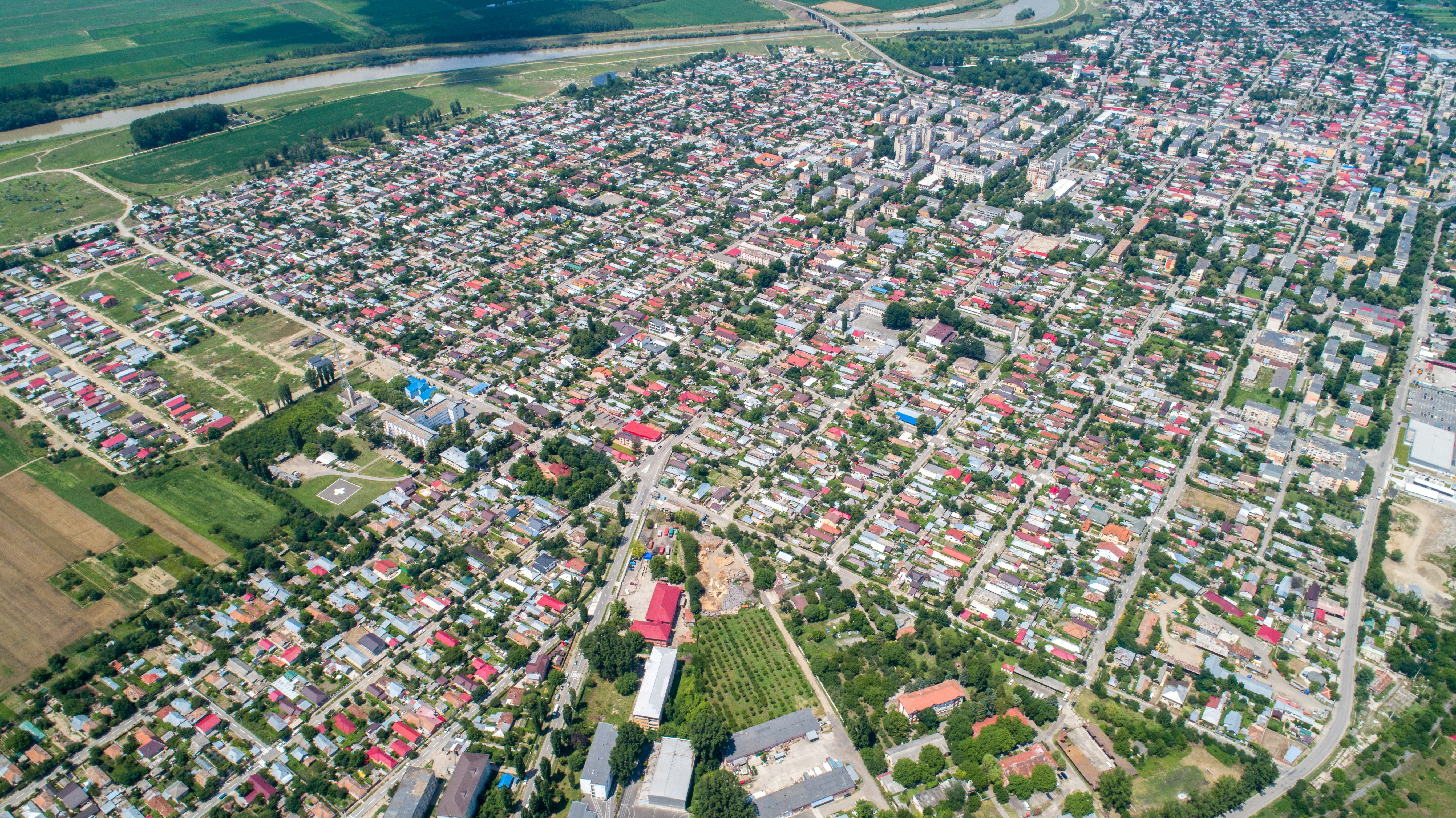 Vast aerial view of a suburban neighborhood showcasing a grid of houses, roads, and greenery. The scene highlights the intricate layout and diversity of residential architecture.