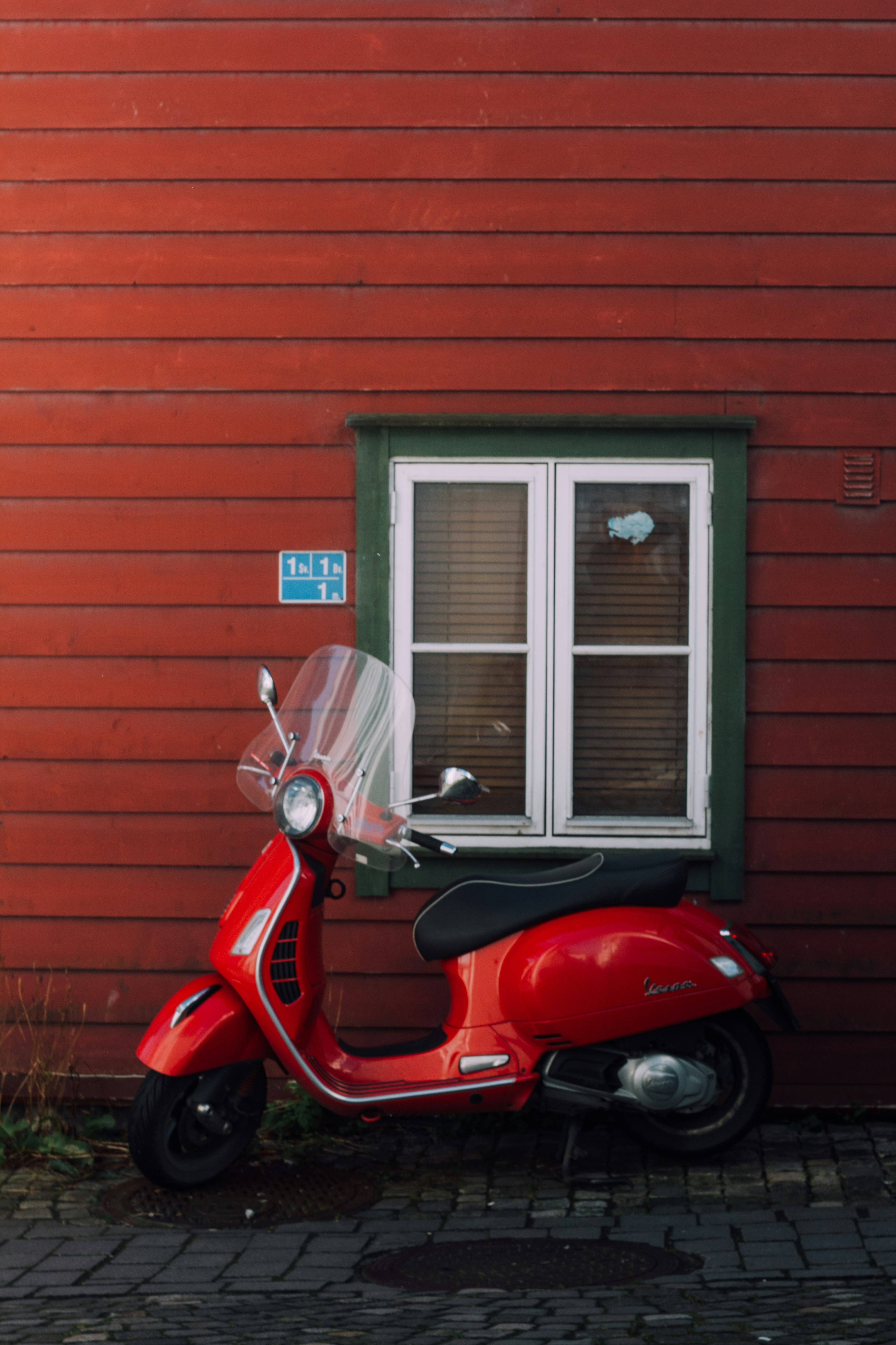 Red Vespa by a Worn-Red Wall
