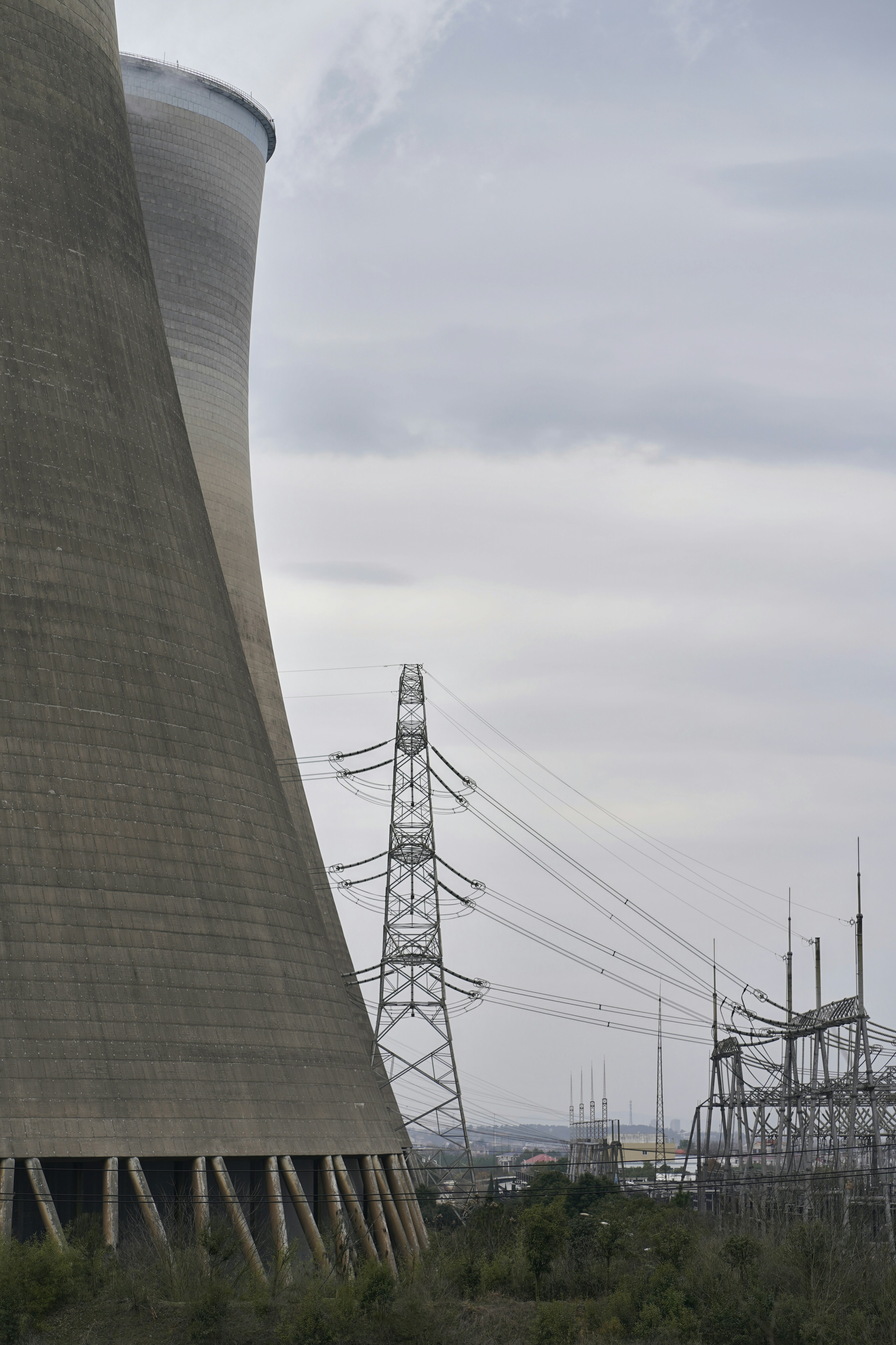 A view of a power plant with power lines in the background photo – Free ...