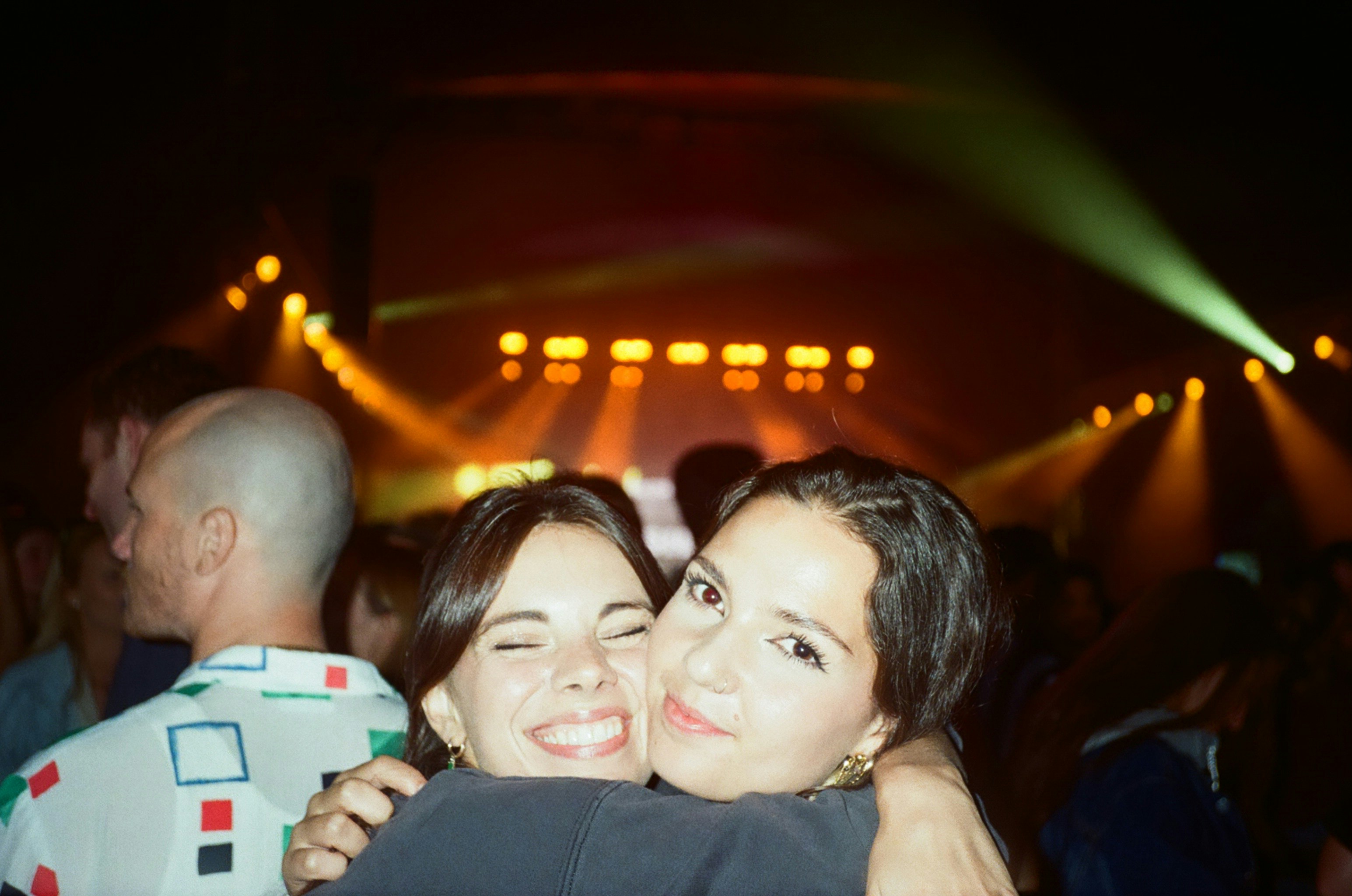 Two women hugging each other in front of a crowd photo – Free Party ...