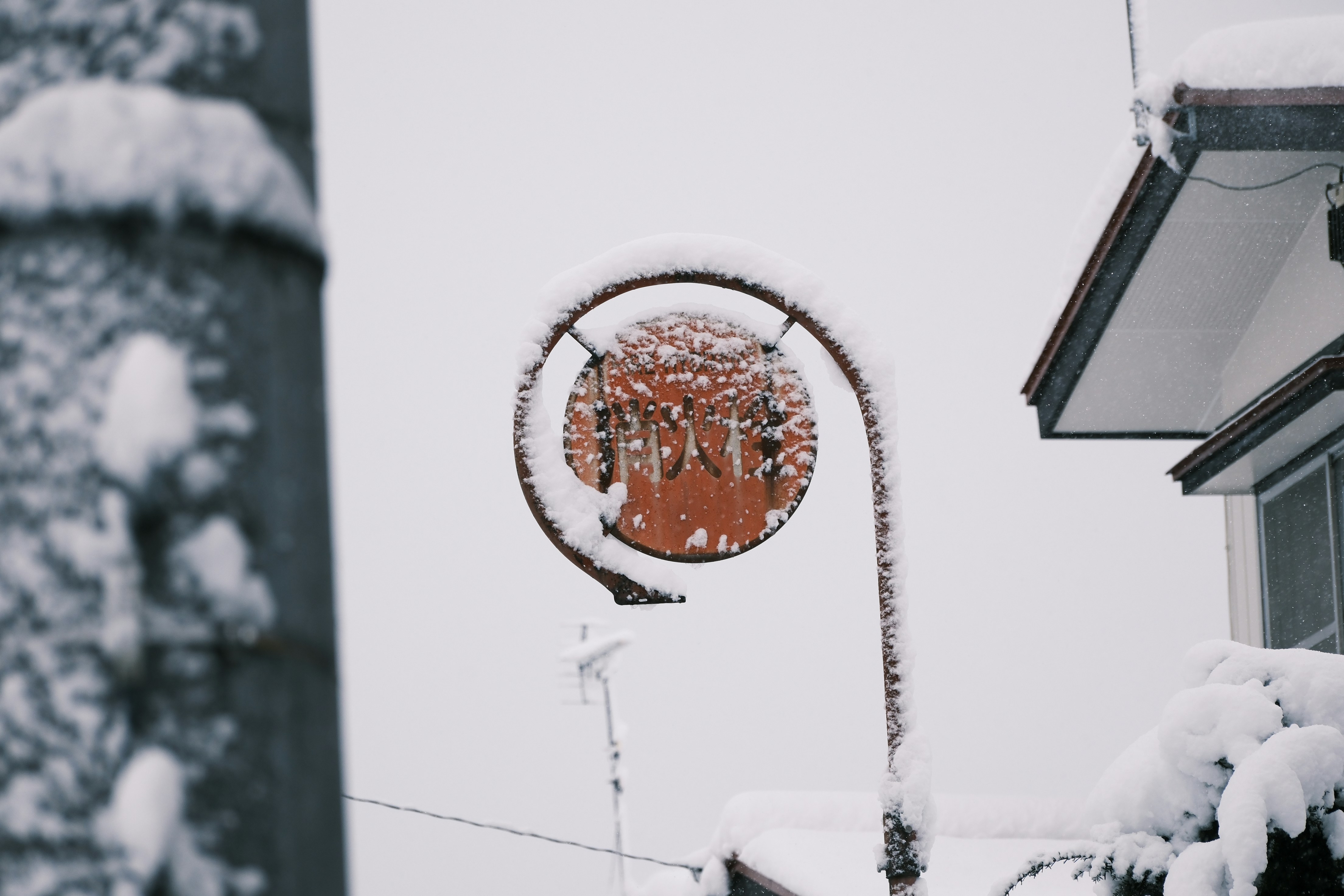 Snow-Covered Circular Sign Framing a Quiet Winter Street