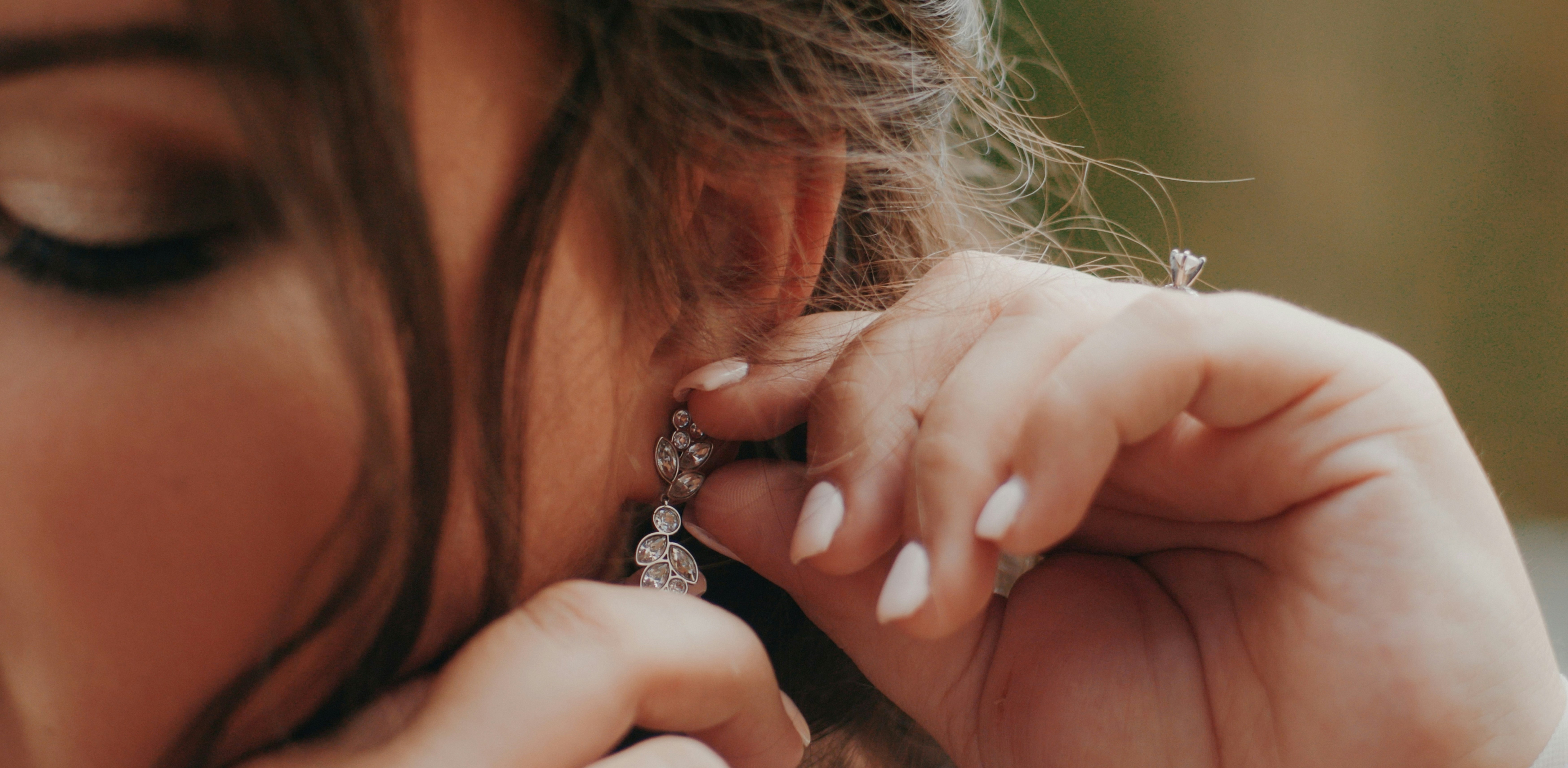 A close up of a person putting on a pair of earrings photo – Free Human ...