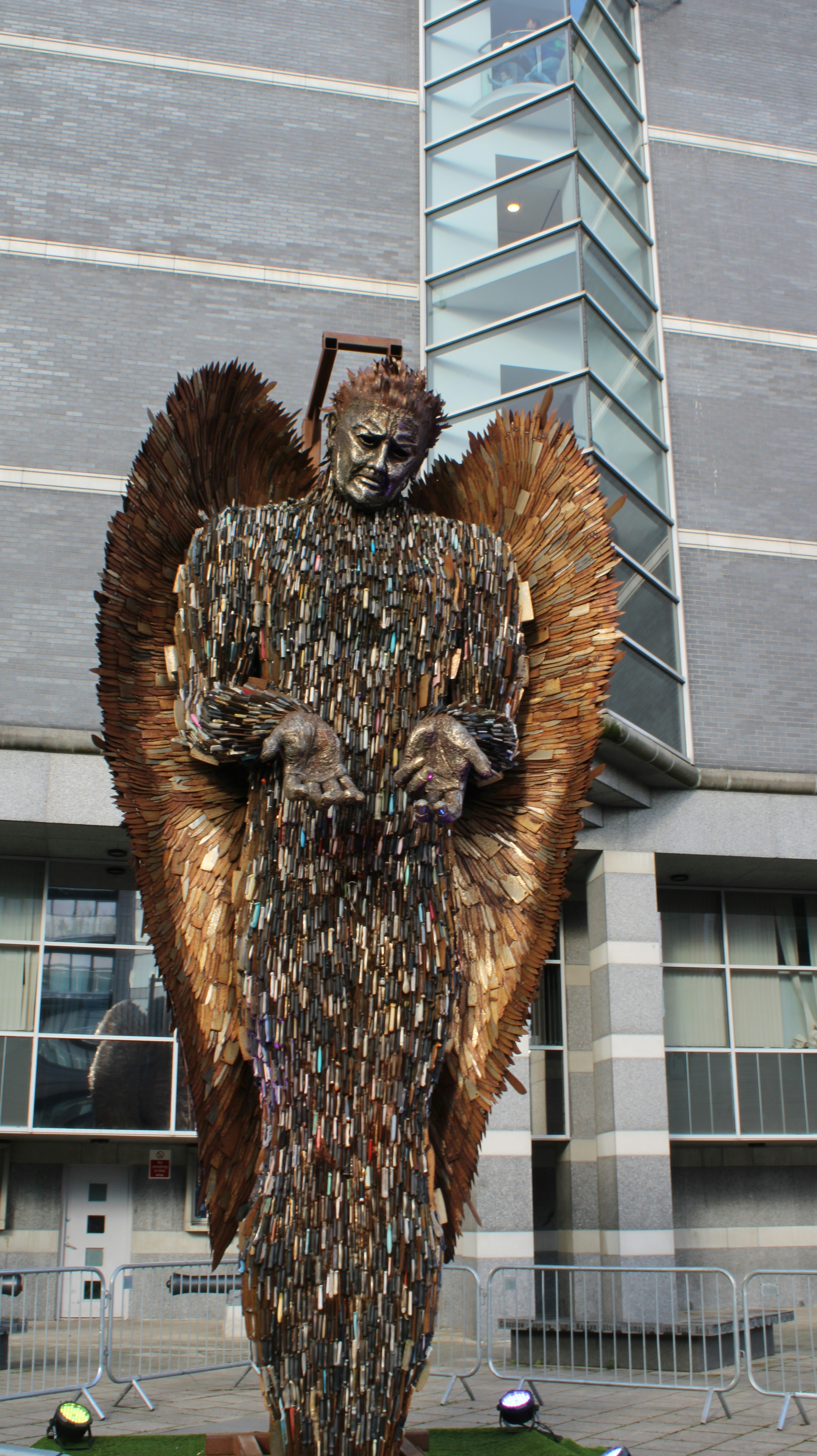 A statue of an angel holding a sword in front of a building photo ...