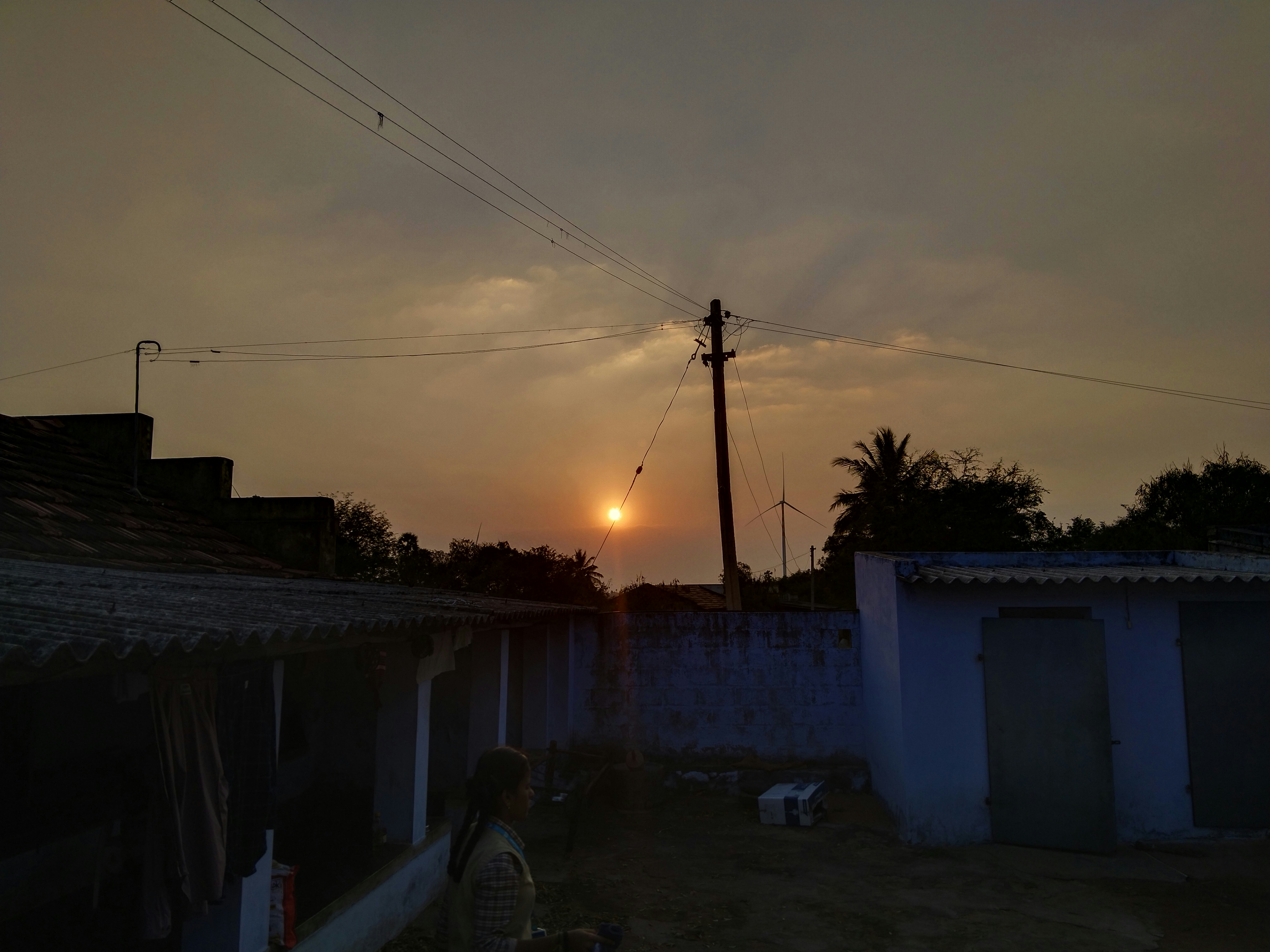 the sun is setting over a small village