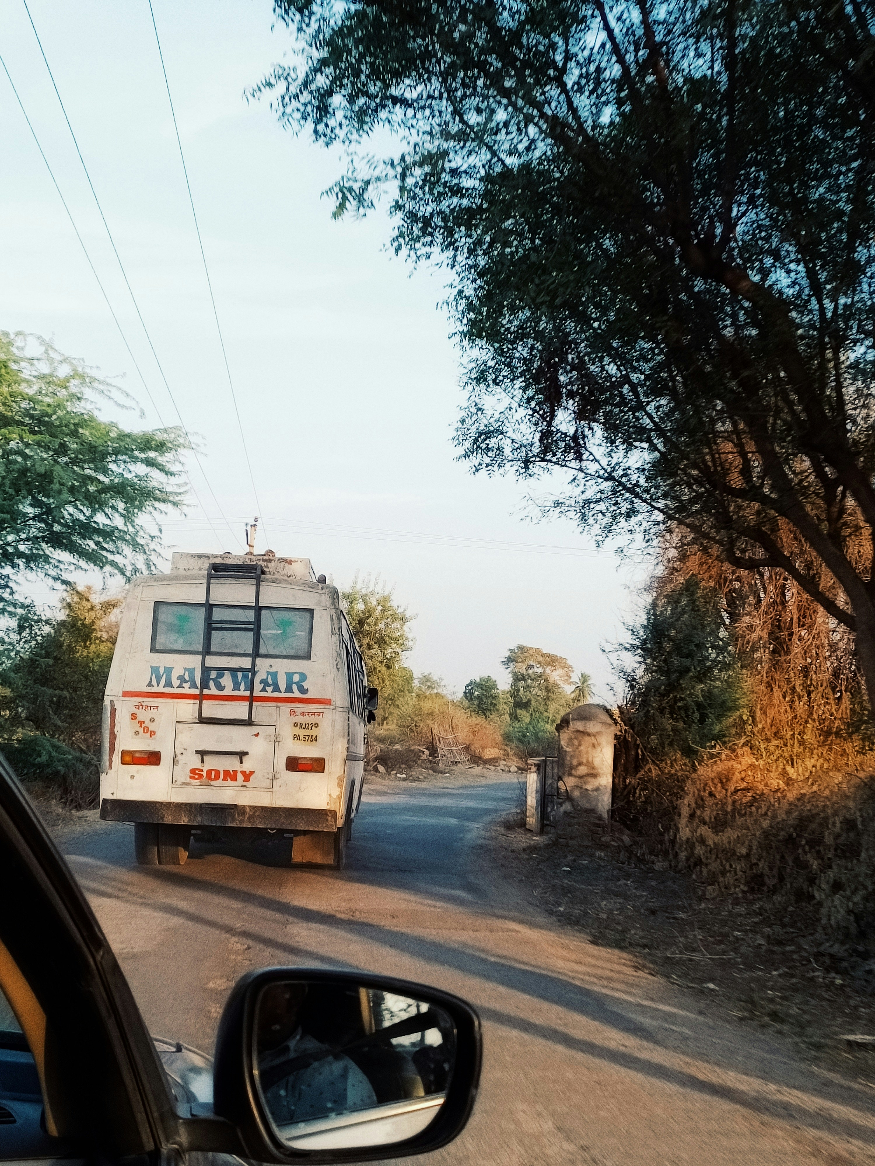 A bus driving down a dirt road next to a forest photo – Free Road Image ...