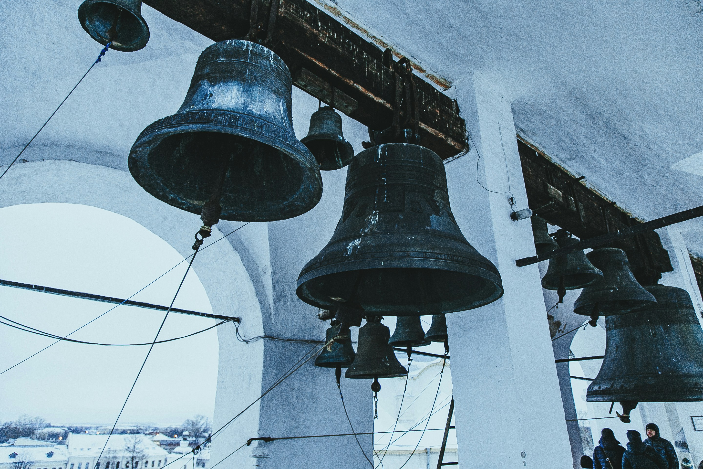 A group of bells hanging from the ceiling of a building photo – Free ...