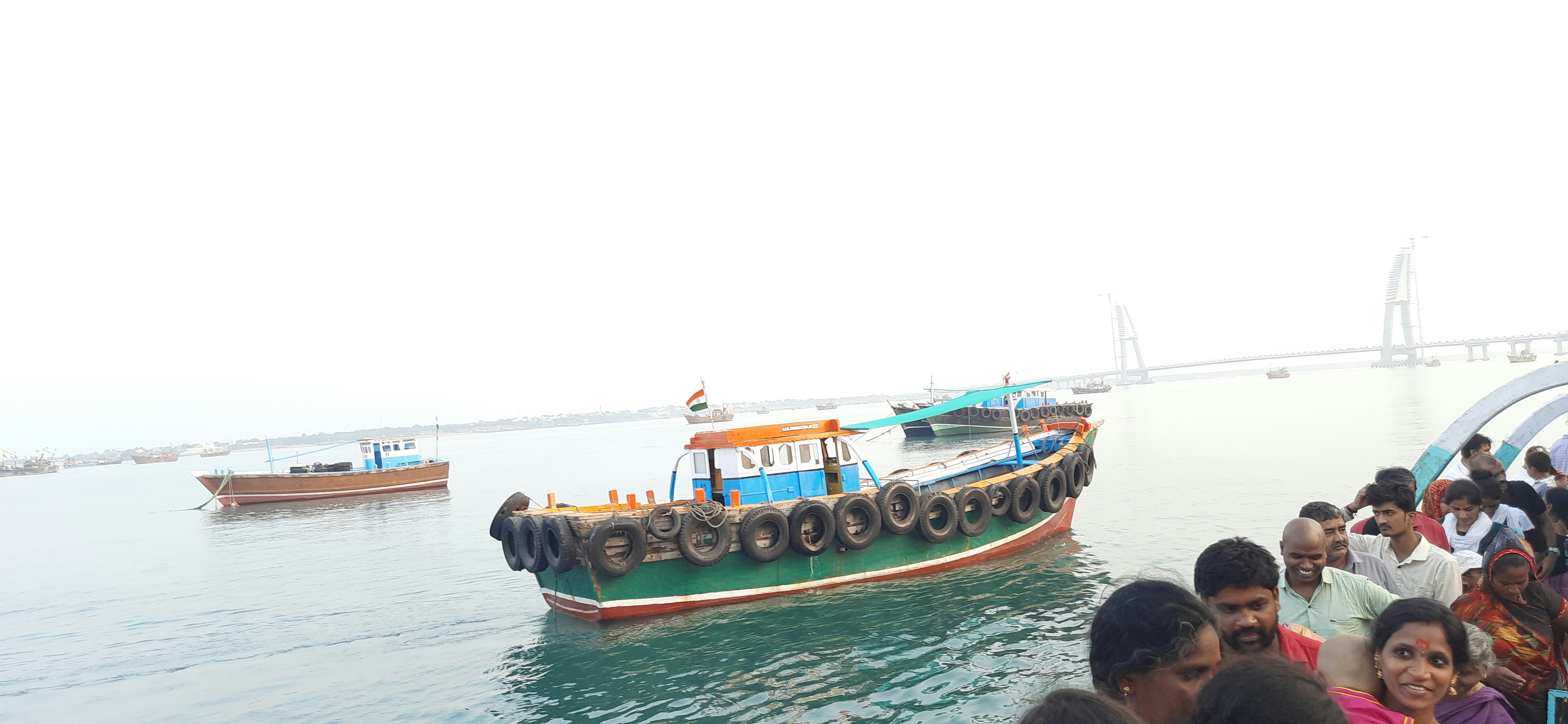 Orange-Cap Tugboat Sails Past a Packed Waterfront Crowd