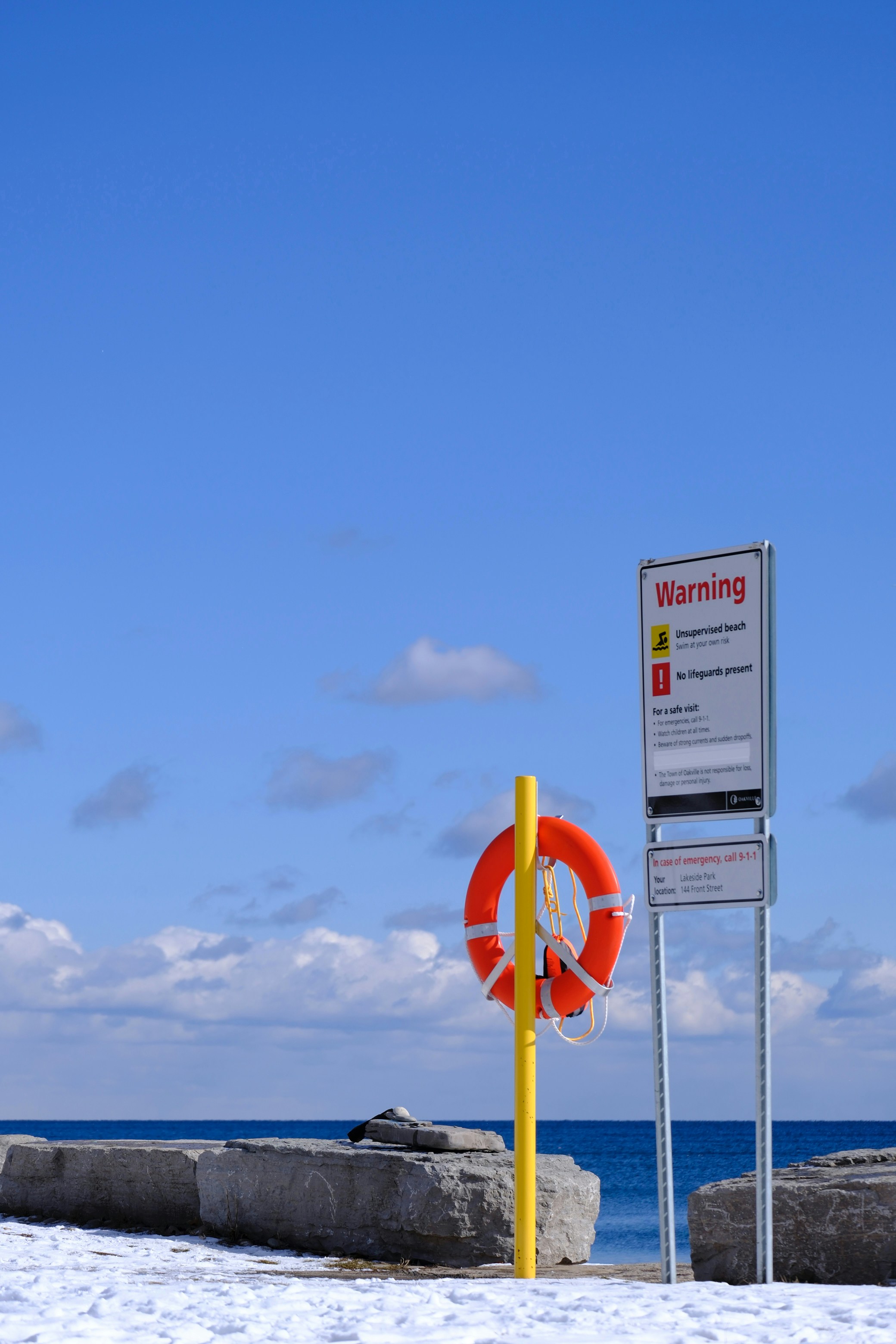 Lifebuoy Sentinel by a Snow-Kissed Seaside Warning