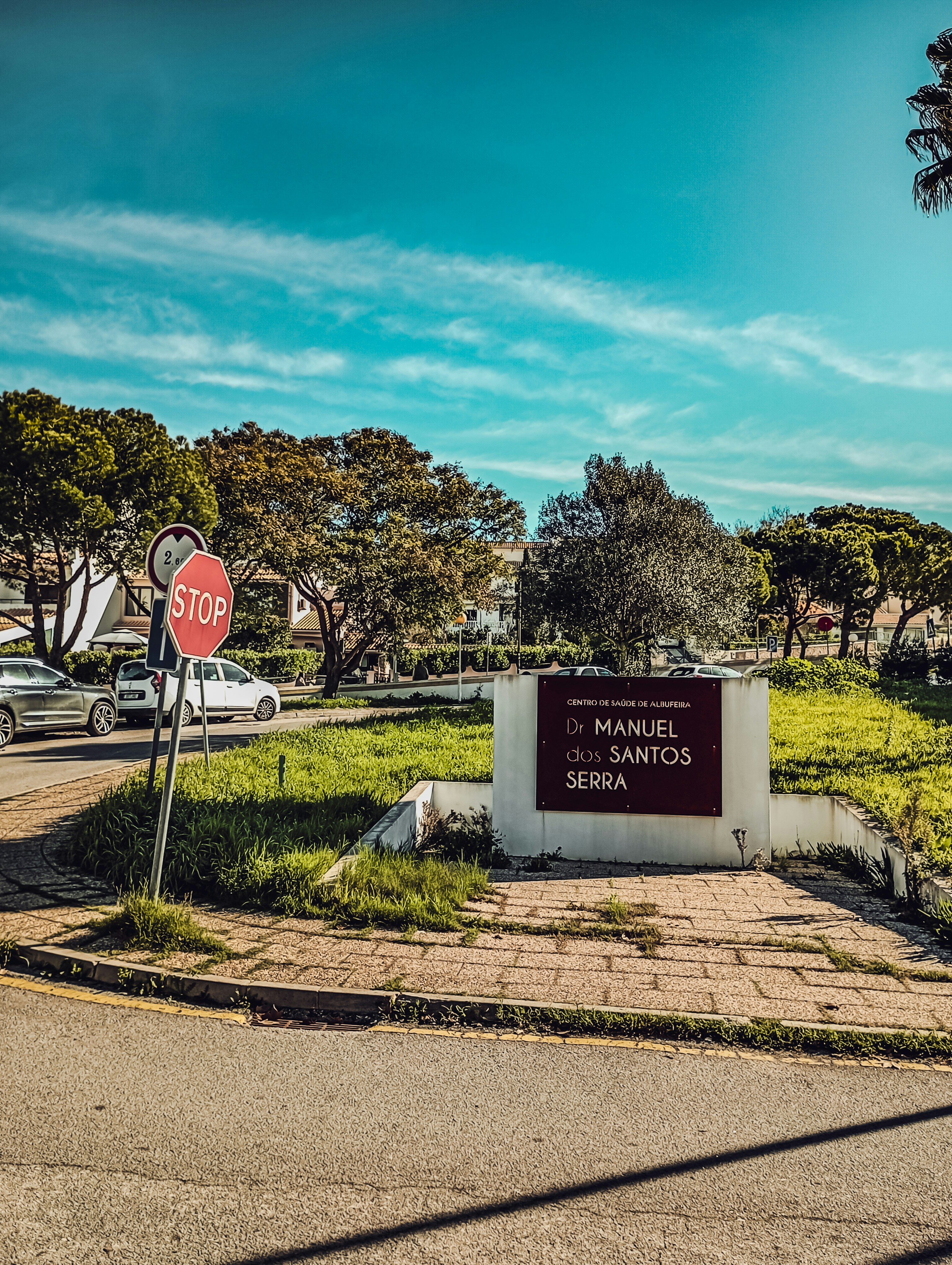 A Quiet Campus Entrance: Stop Sign by the Signboard