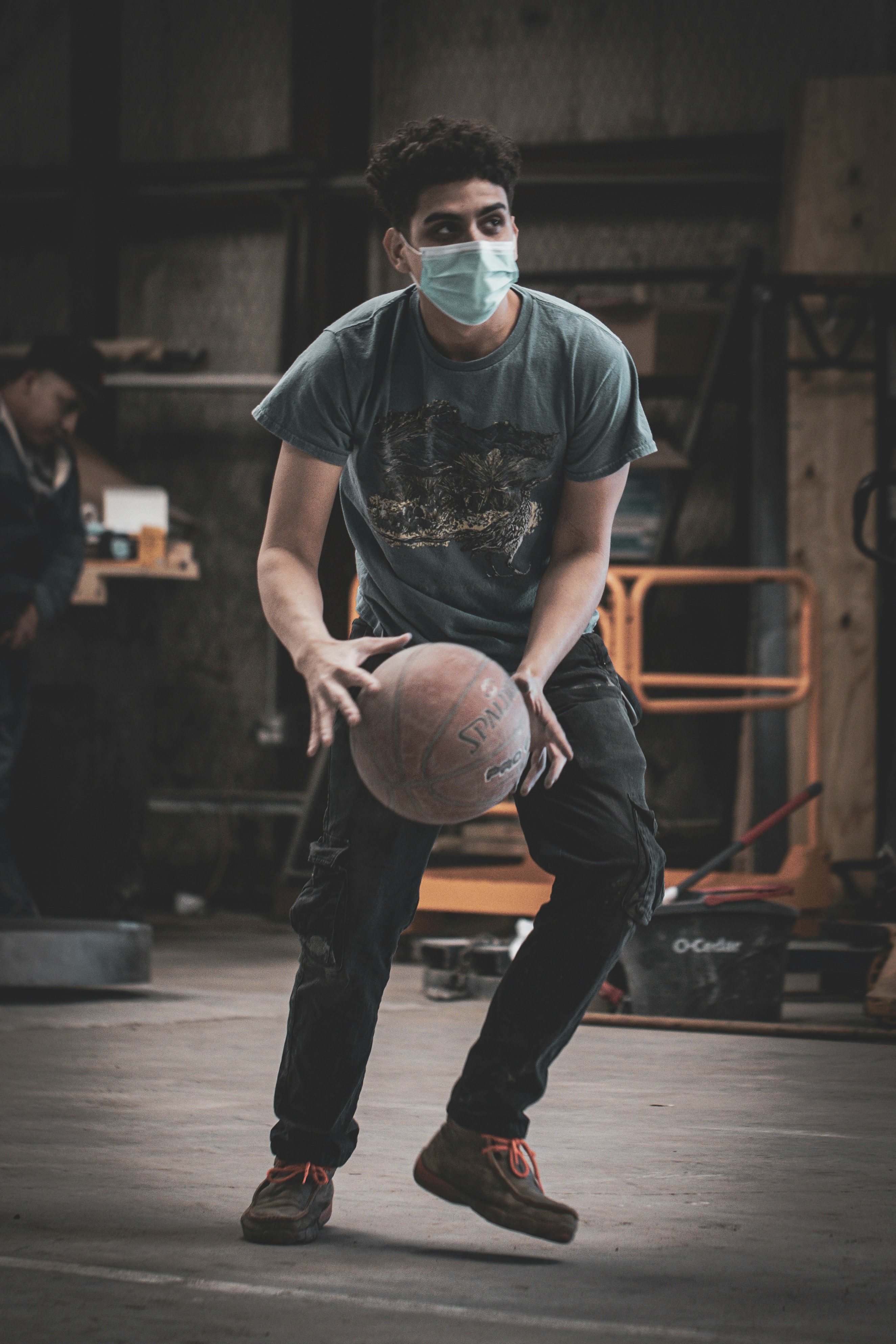 A man holding a basketball while wearing a face mask photo – Free ...