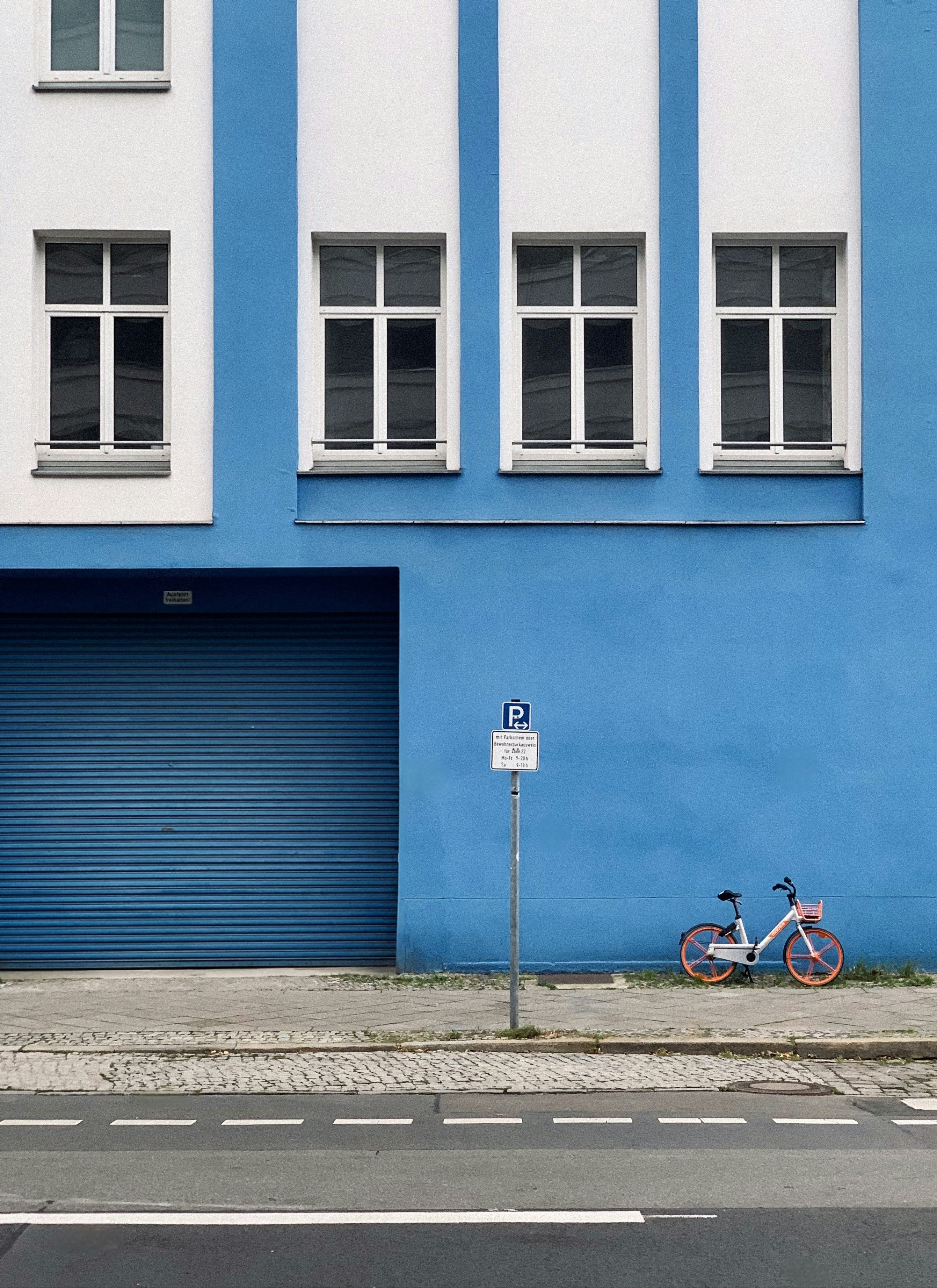 Un vélo garé à côté d’un bâtiment bleu photo – Photo Photographie de ...