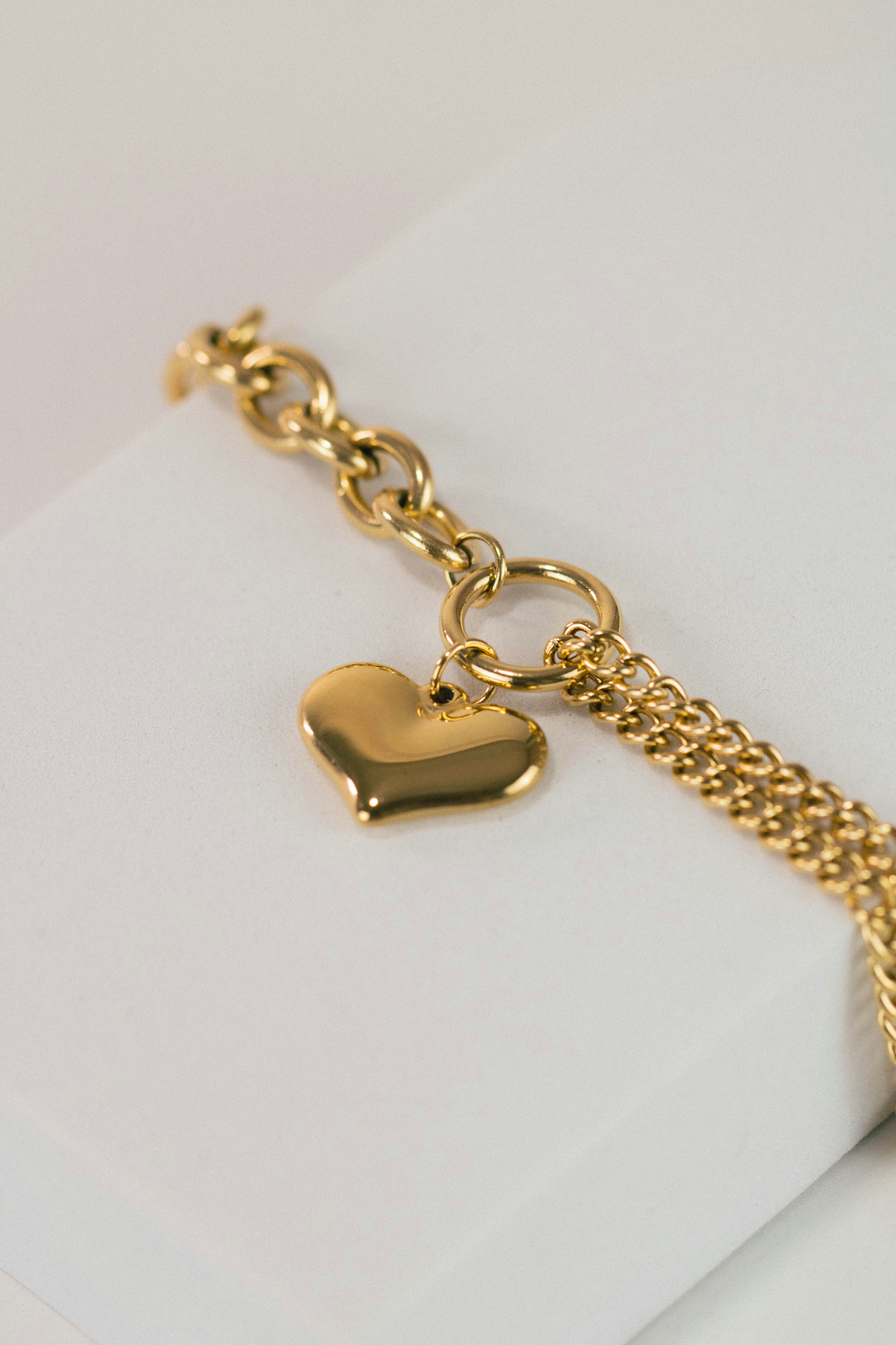 A gold chain bracelet with a heart charm photo – Free Brown Image on ...