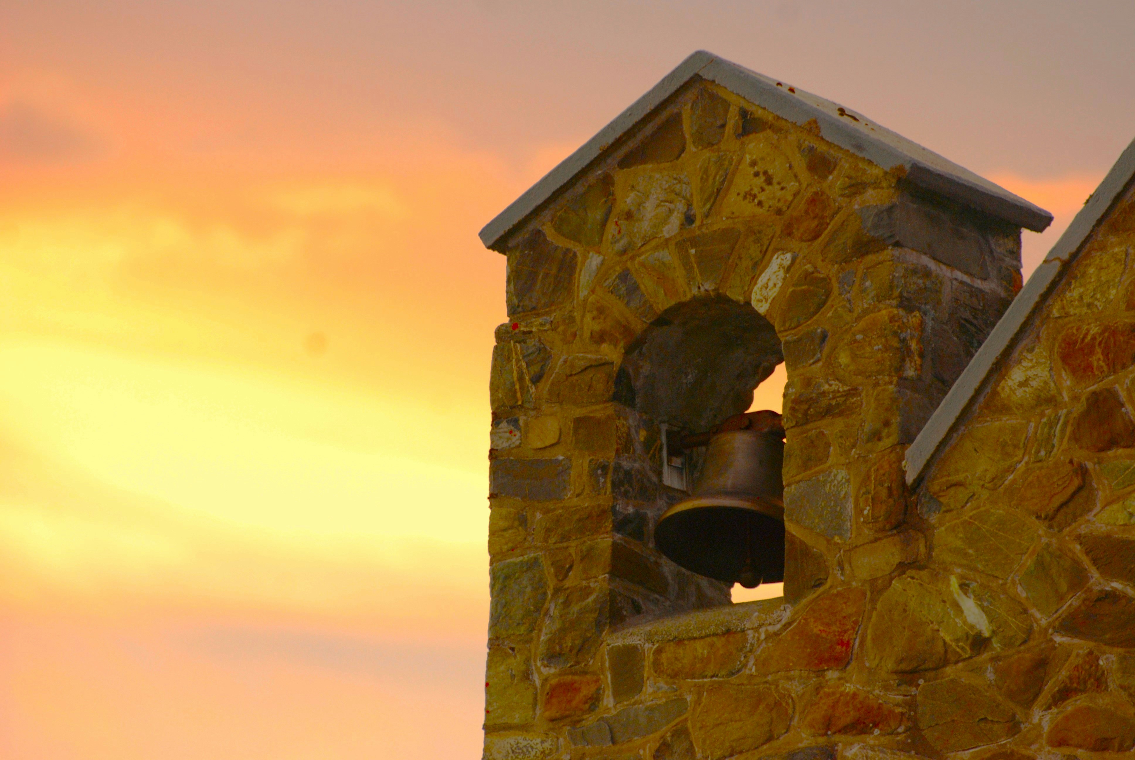 Amber Hour Bell: Sunset Light on a Rustic Stone Tower