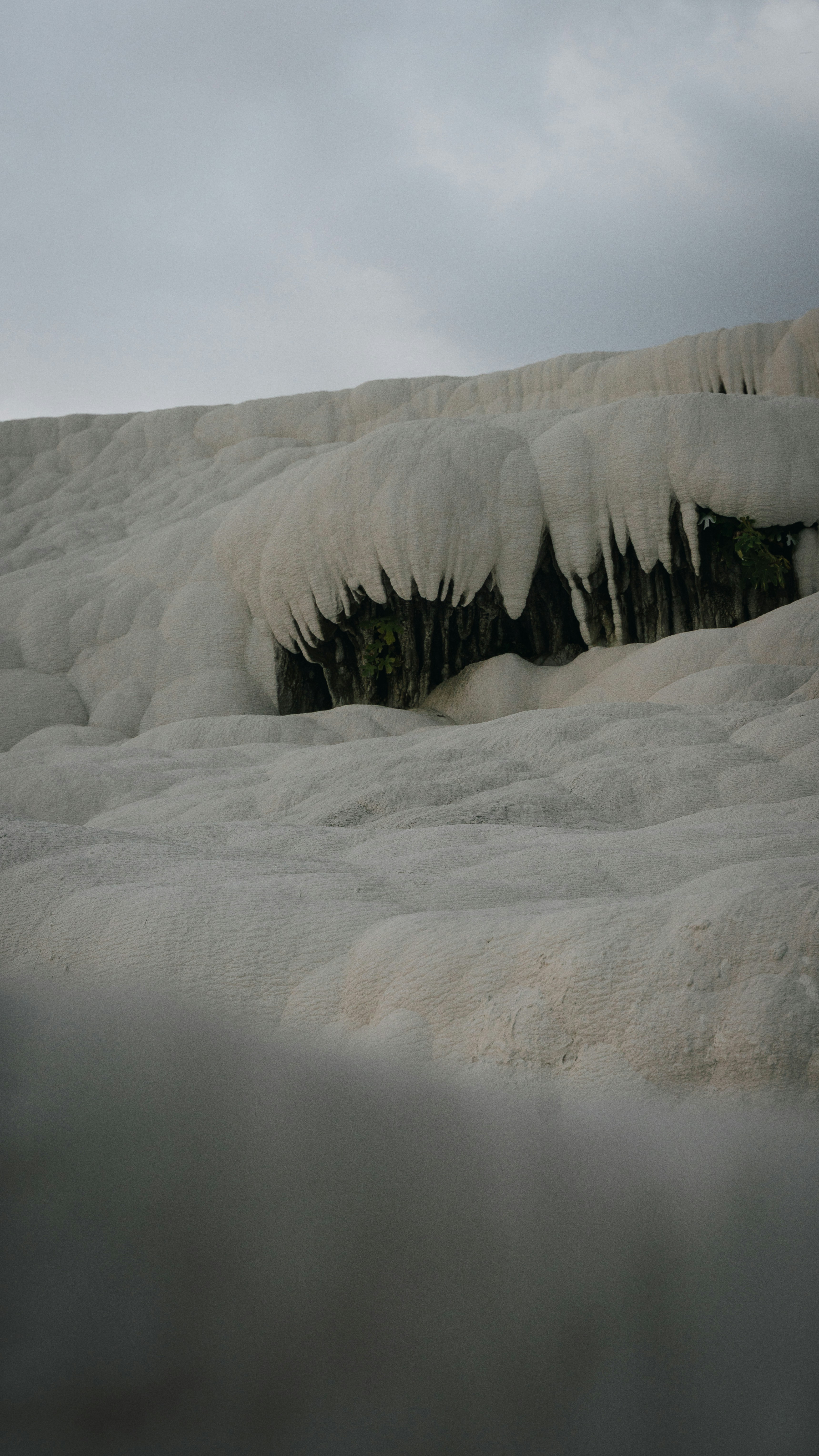 Whispering White Terraces Under a Cloudy Veil