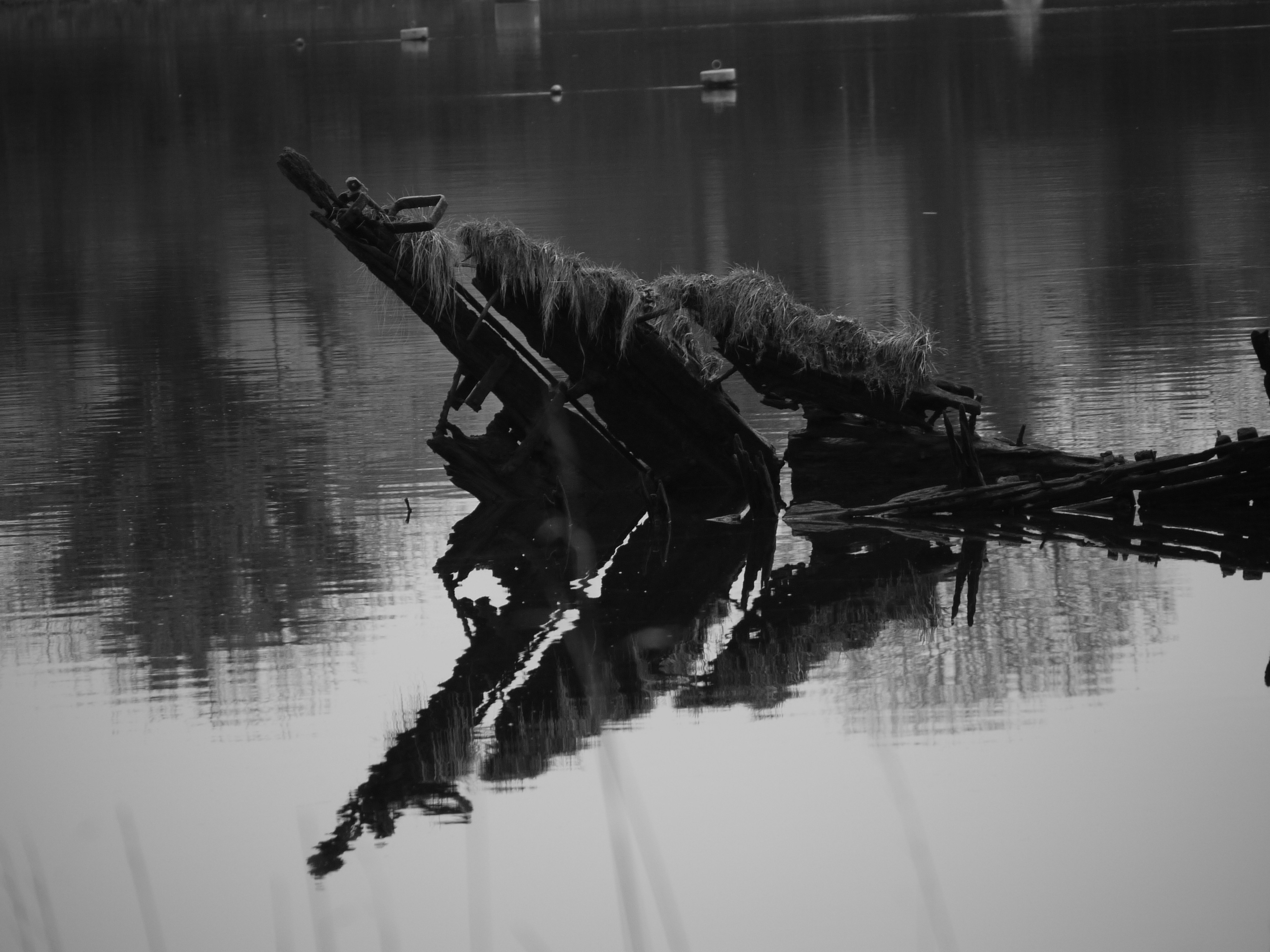 Remnant of a Sail: A Weathered Vessel Resting in Quiet Waters