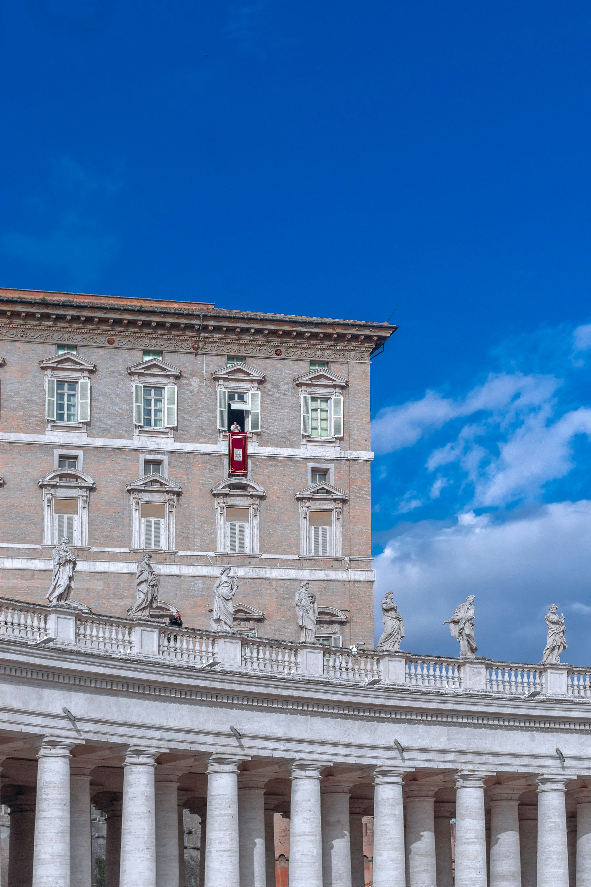 A building with columns and a clock tower in the background photo ...