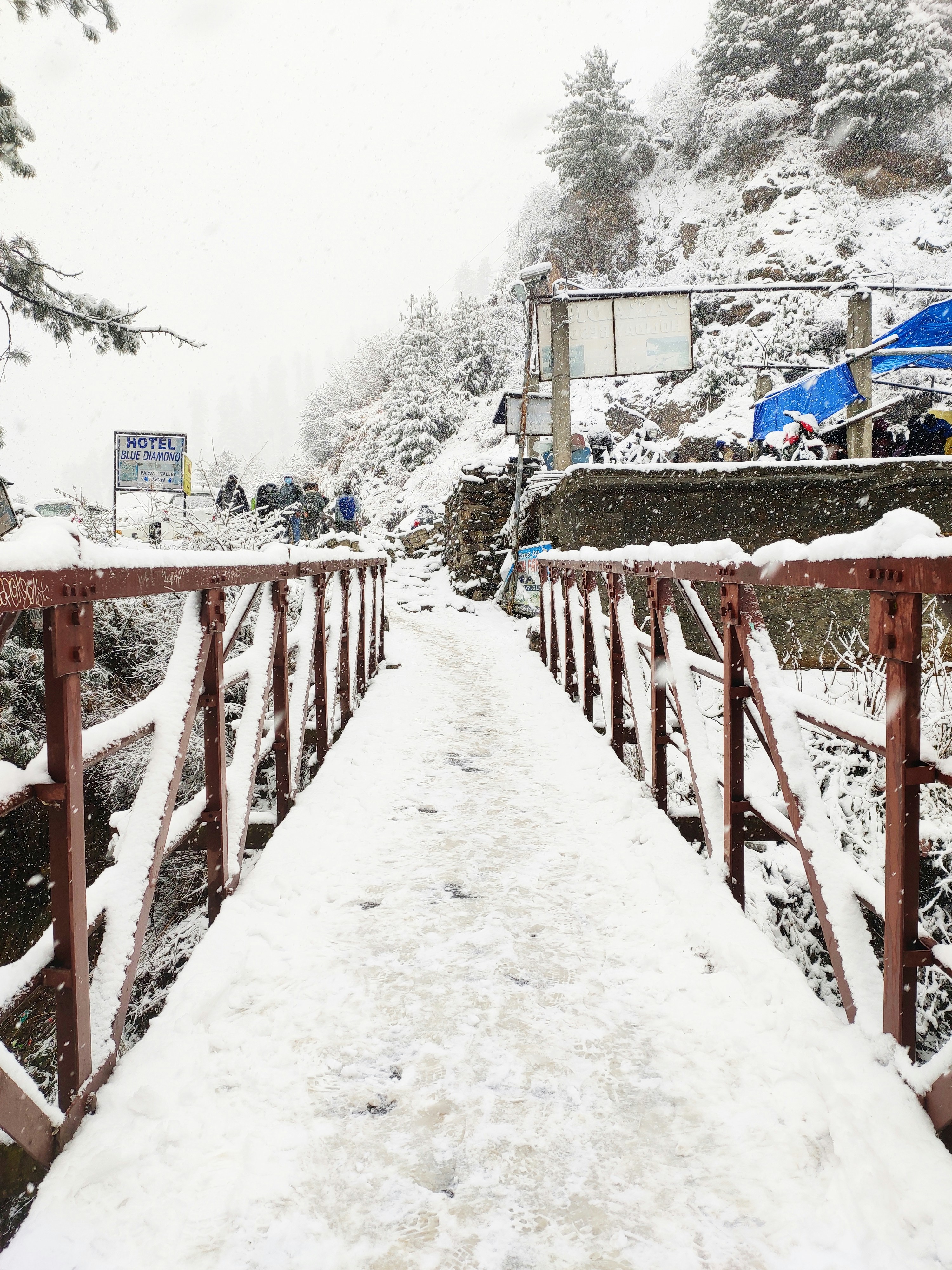 Vanishing Bridge: Snowbound Walkway Toward a Quiet Mountain Outpost