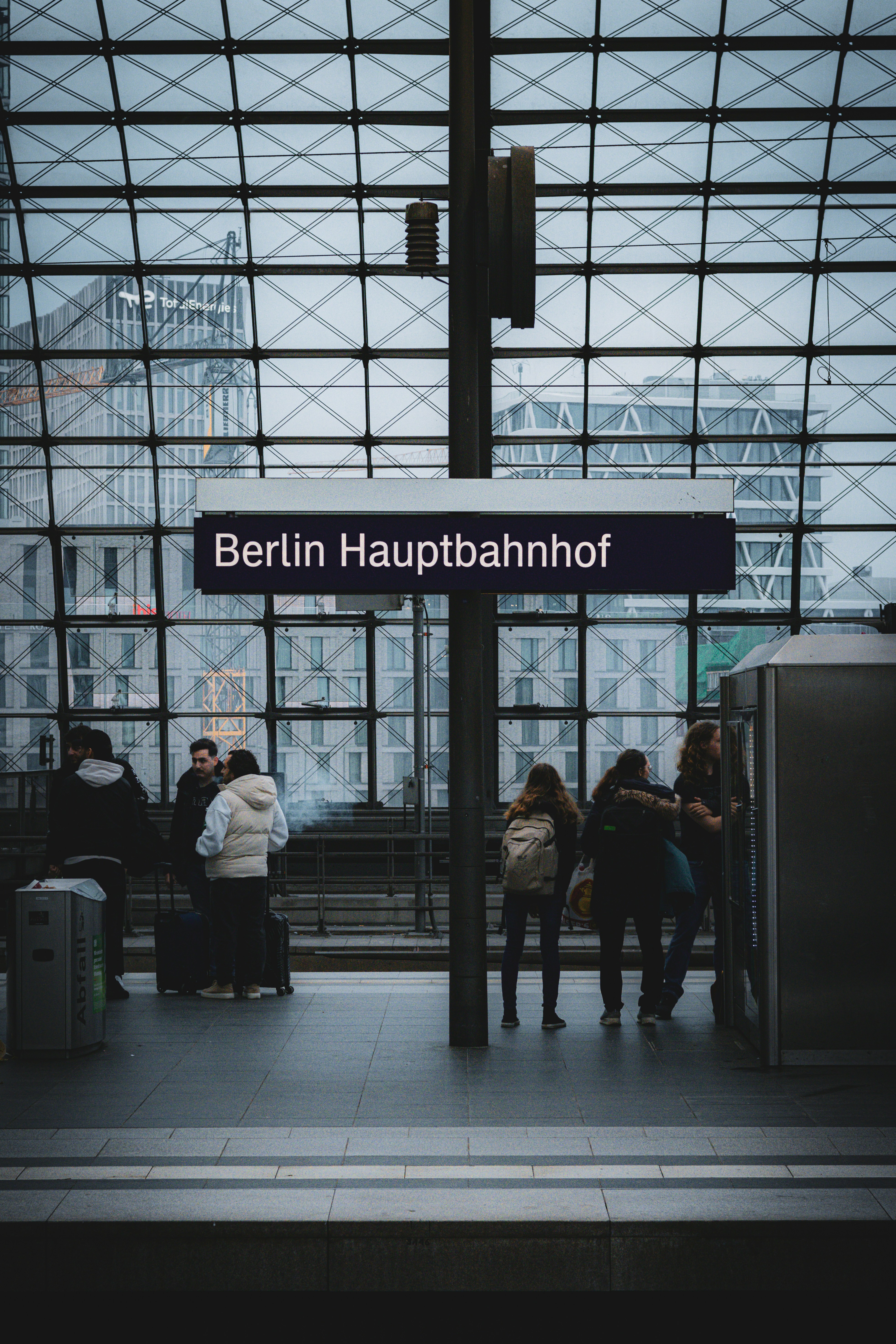 Under the Glass Canopy: Commuters Pause at Berlin Hauptbahnhof