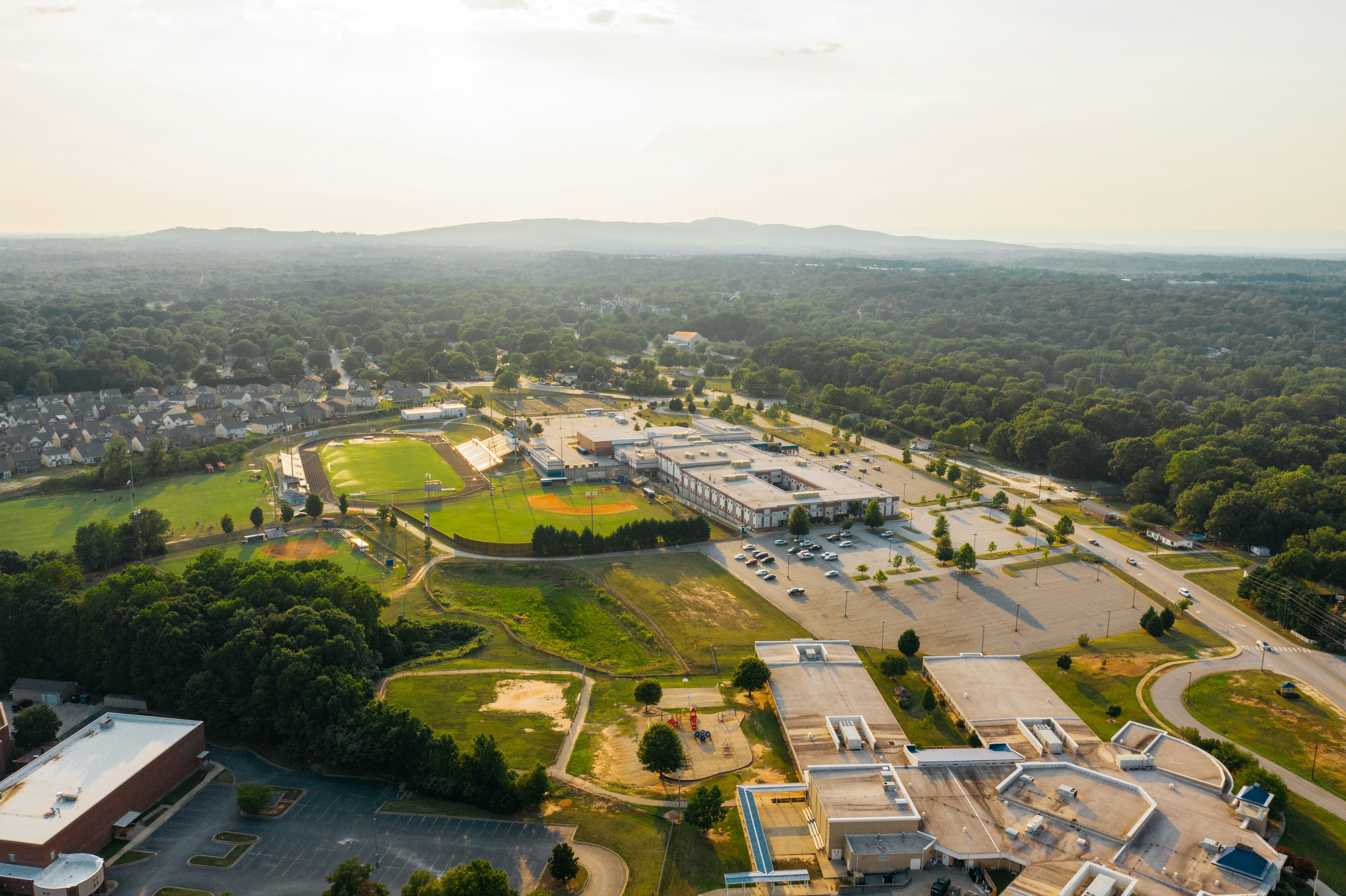An aerial view of a school campus with mountains in the background ...