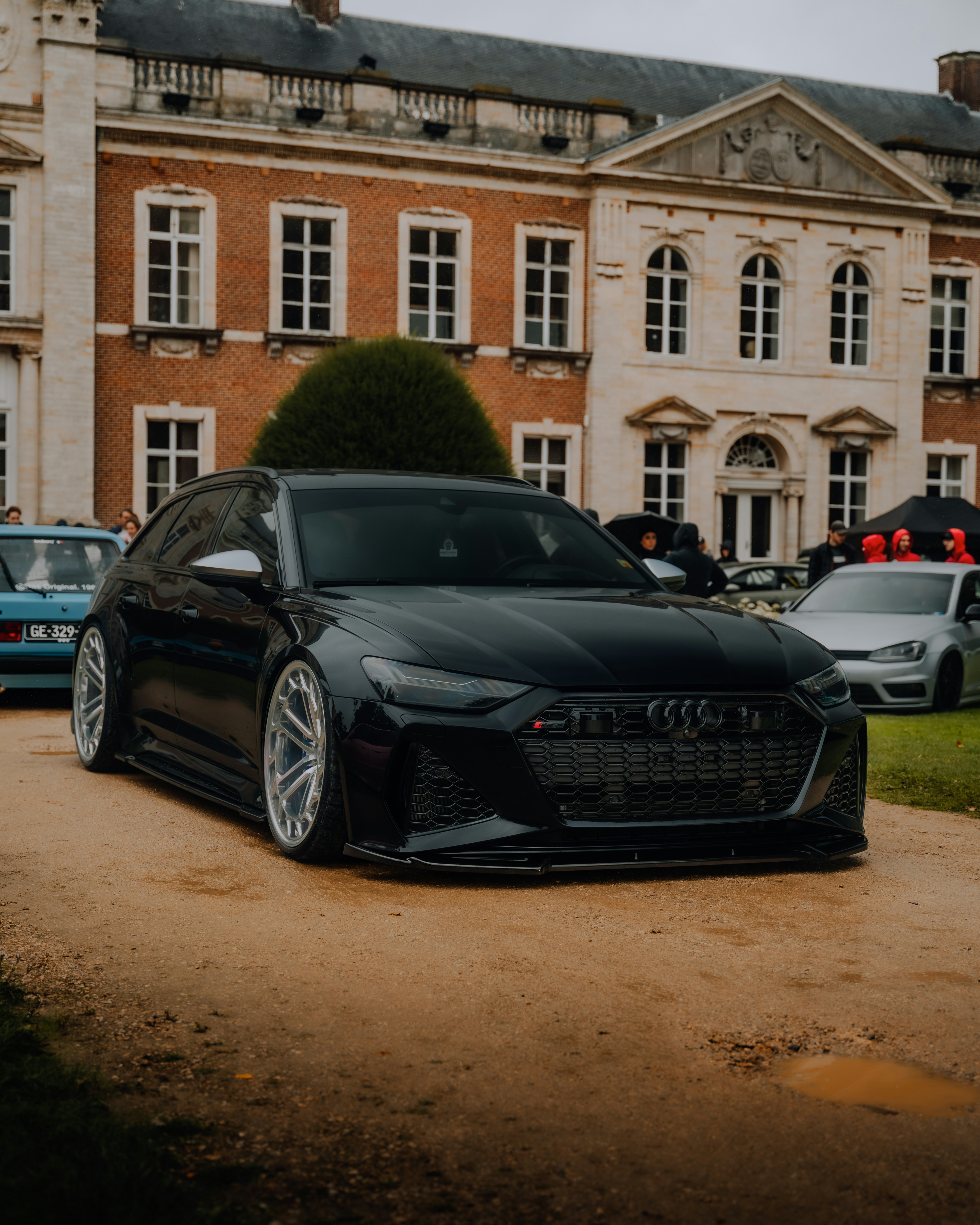 Midnight Audi RS on a gravel approach to a stately manor