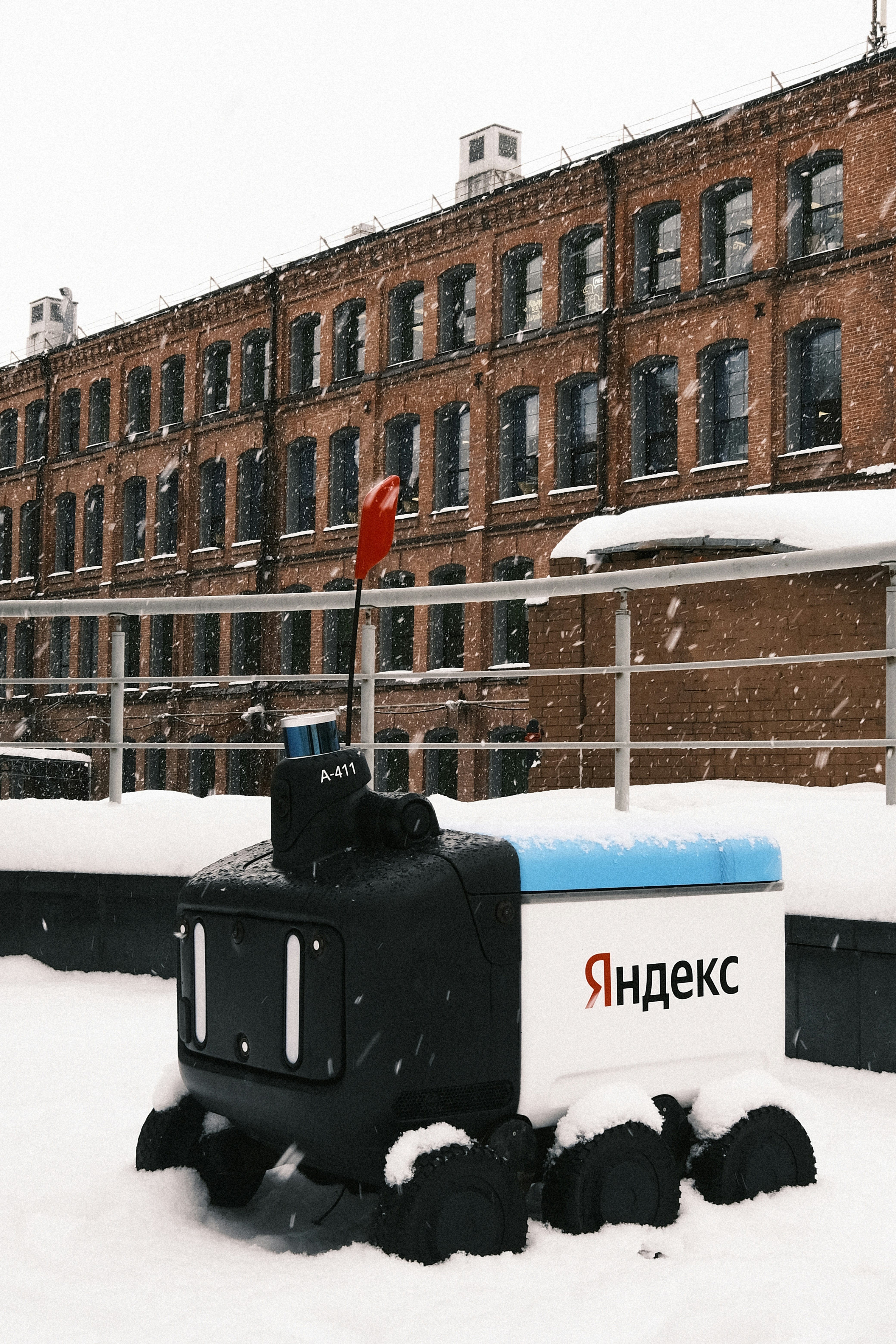A snow plow sitting in the snow in front of a building photo – Free ...