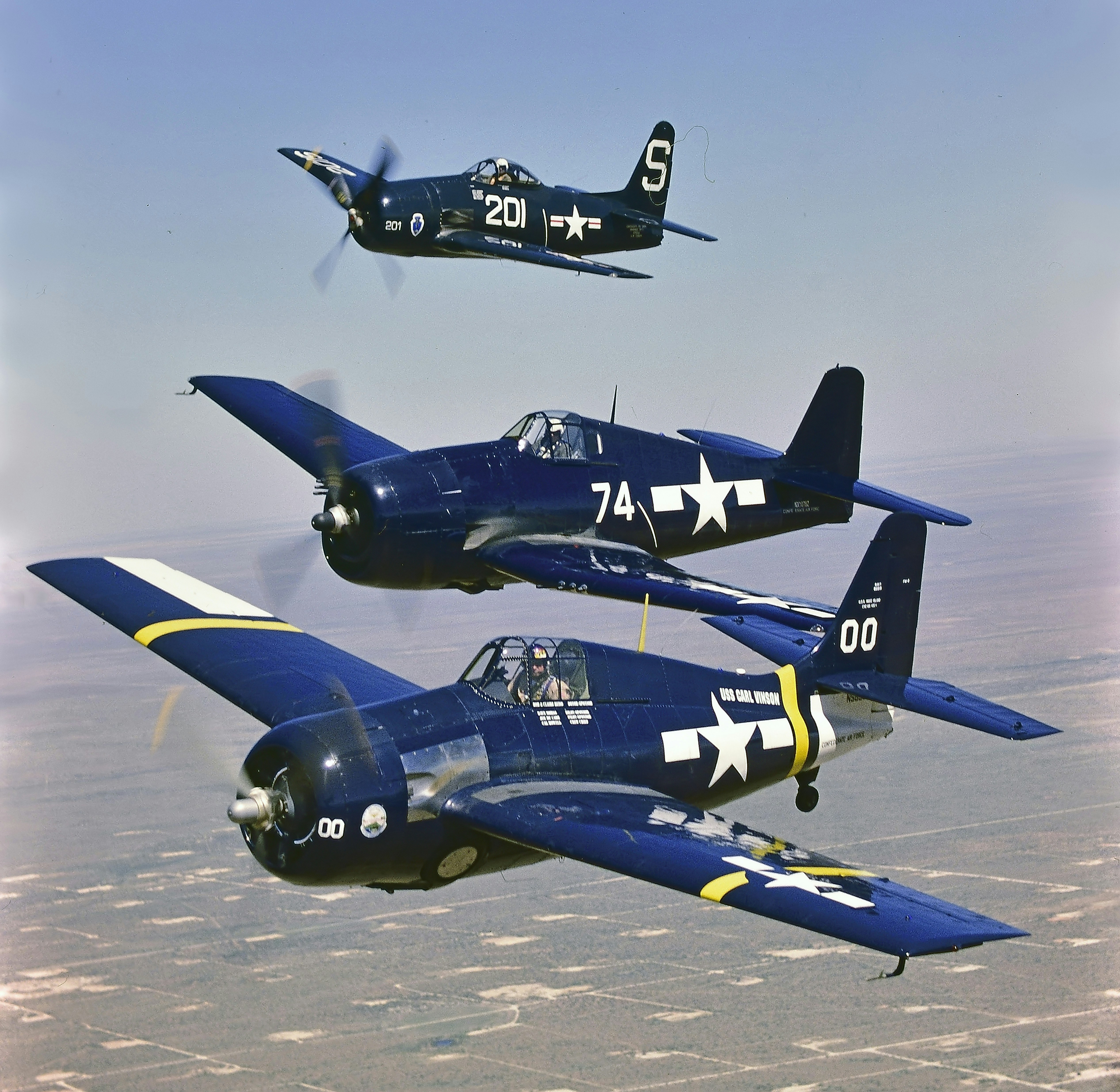 Two blue airplanes flying in the sky above the ground photo – Free ...