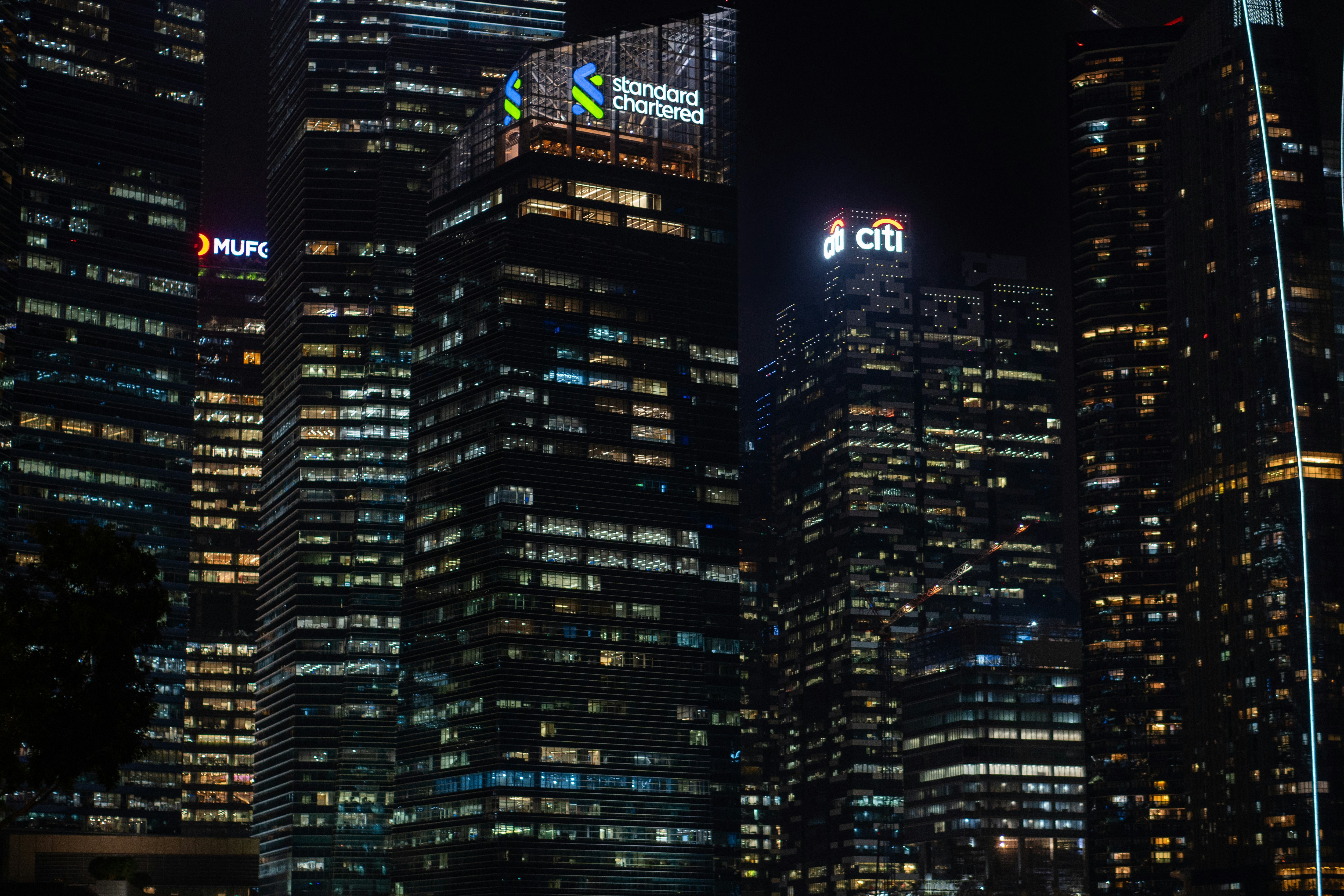 A large group of tall buildings lit up at night photo – Free Singapore ...