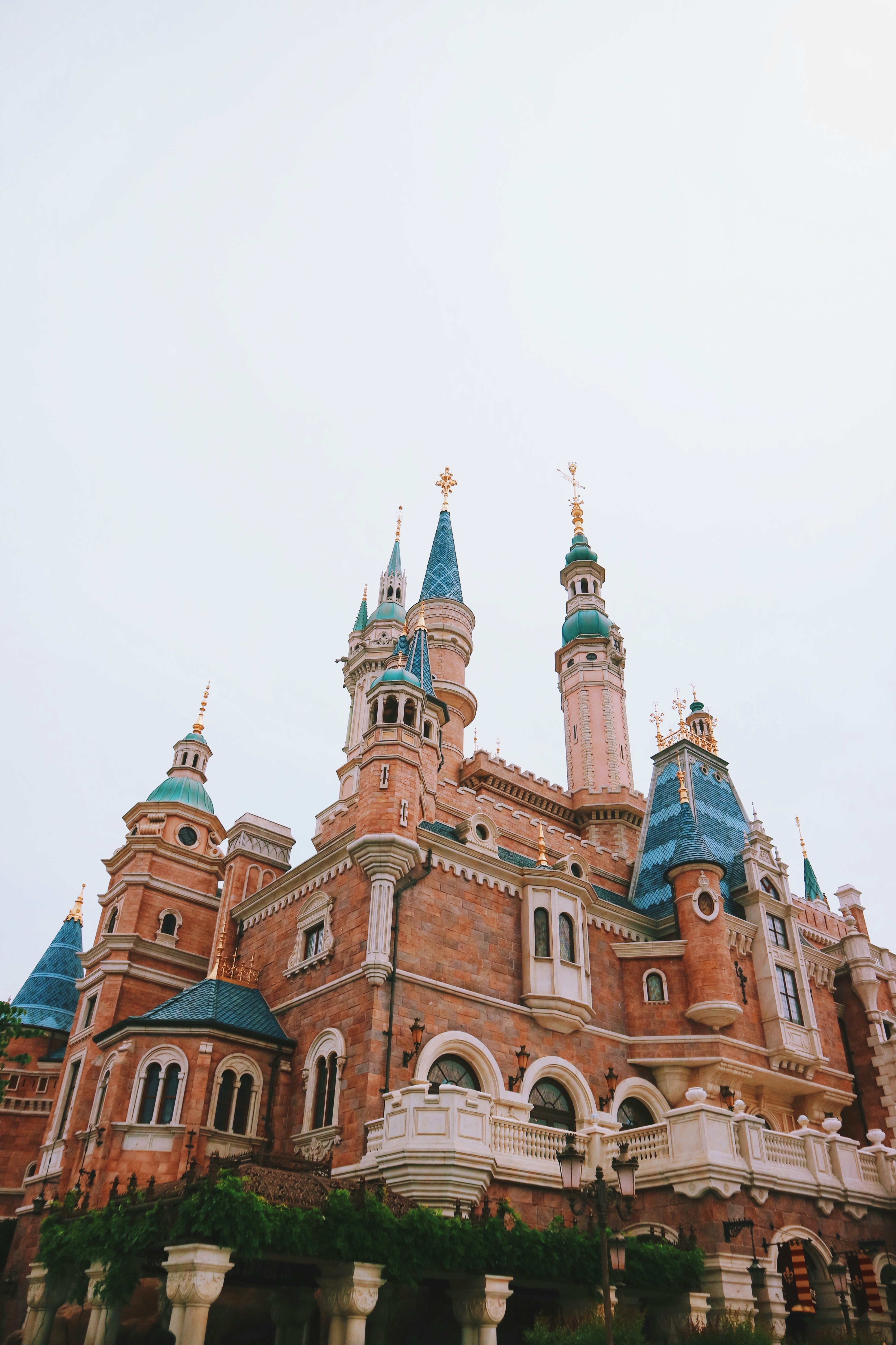 Brick Crowned with Turquoise Spires: A Fairytale Castle Against a Bright Sky