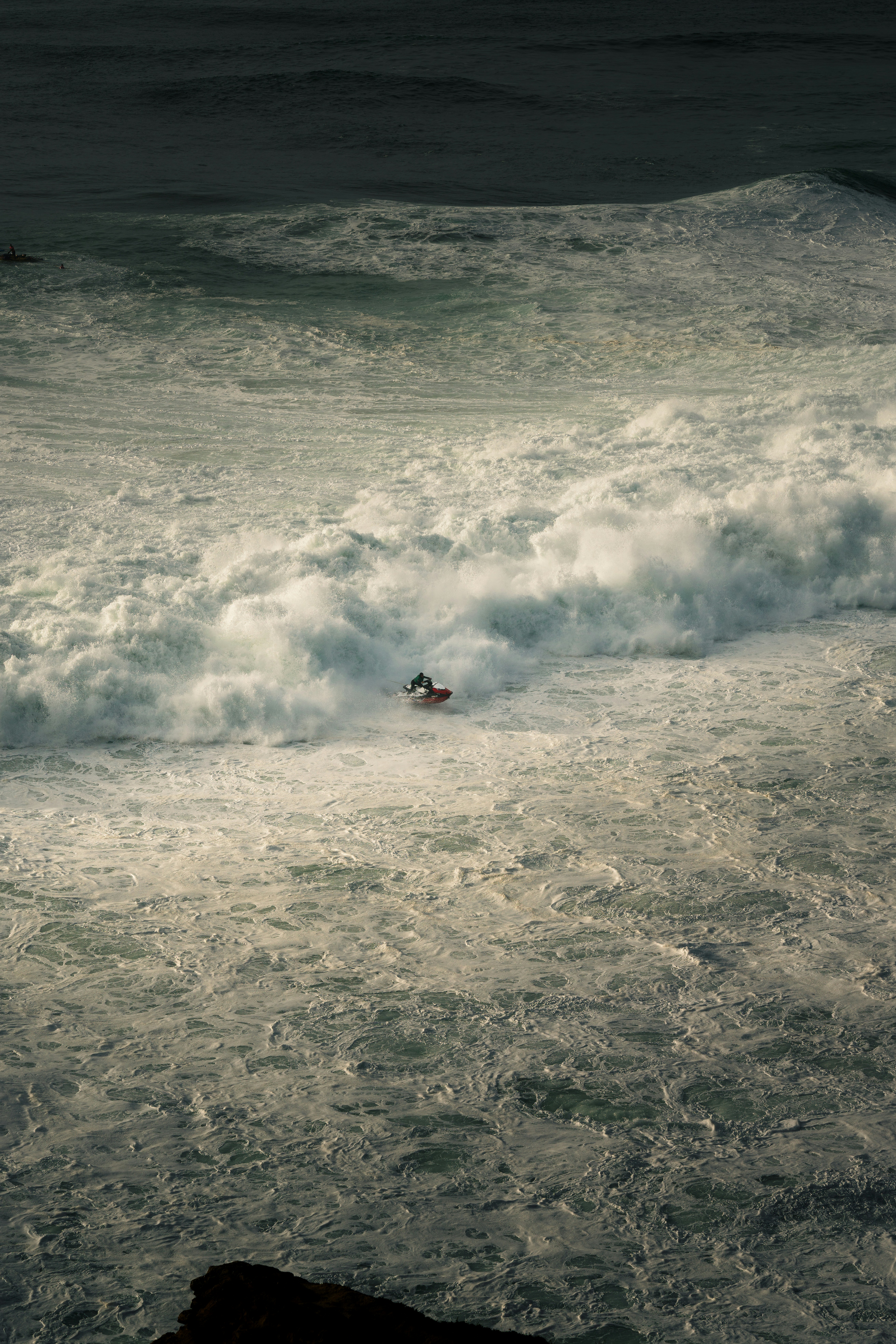 Red Jet Ski Pierces a Cresting Wall of Ocean Foam