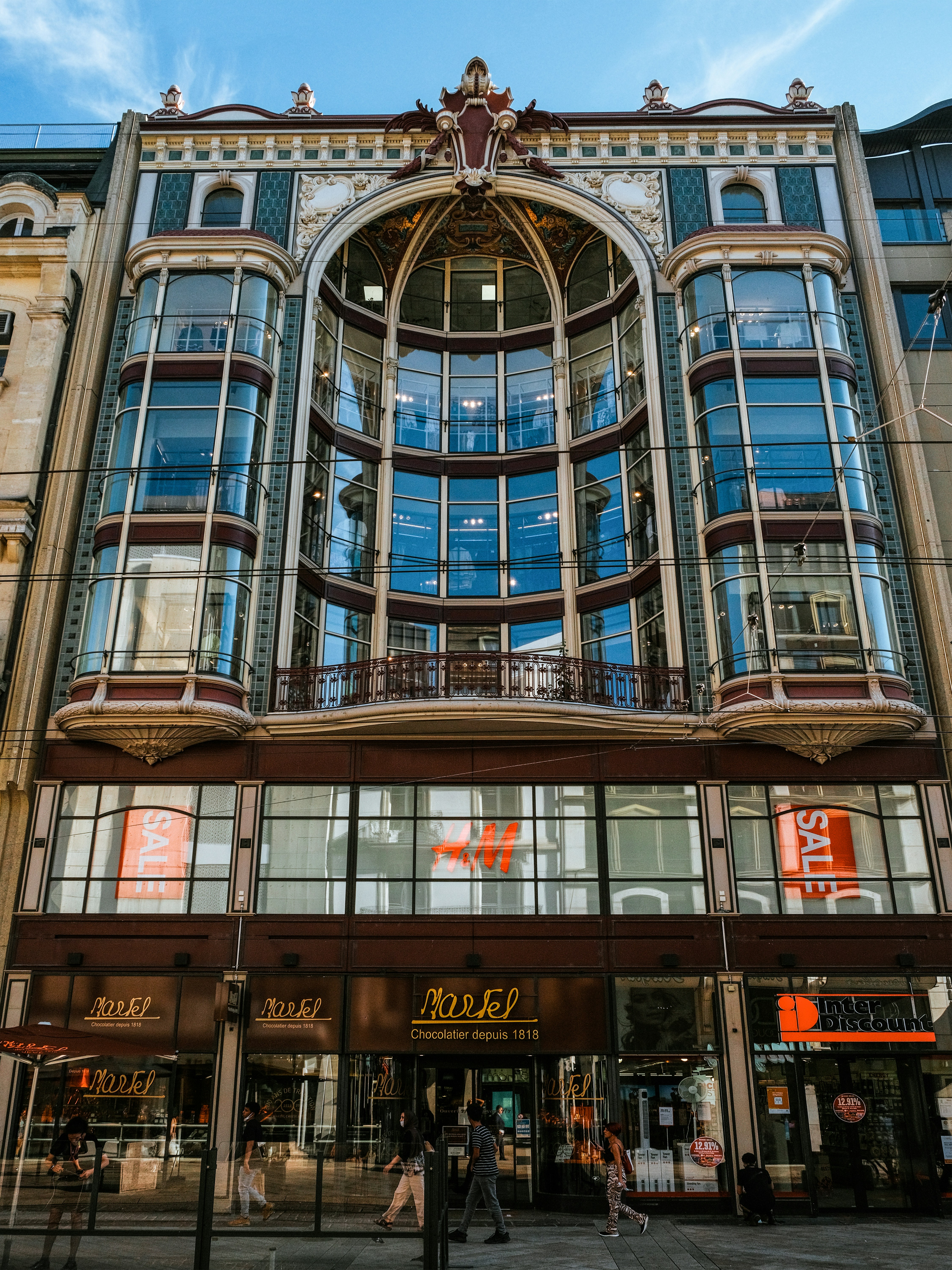 The Grand Arcade: Glass Curves and Ornament Crown a Busy Street Facade