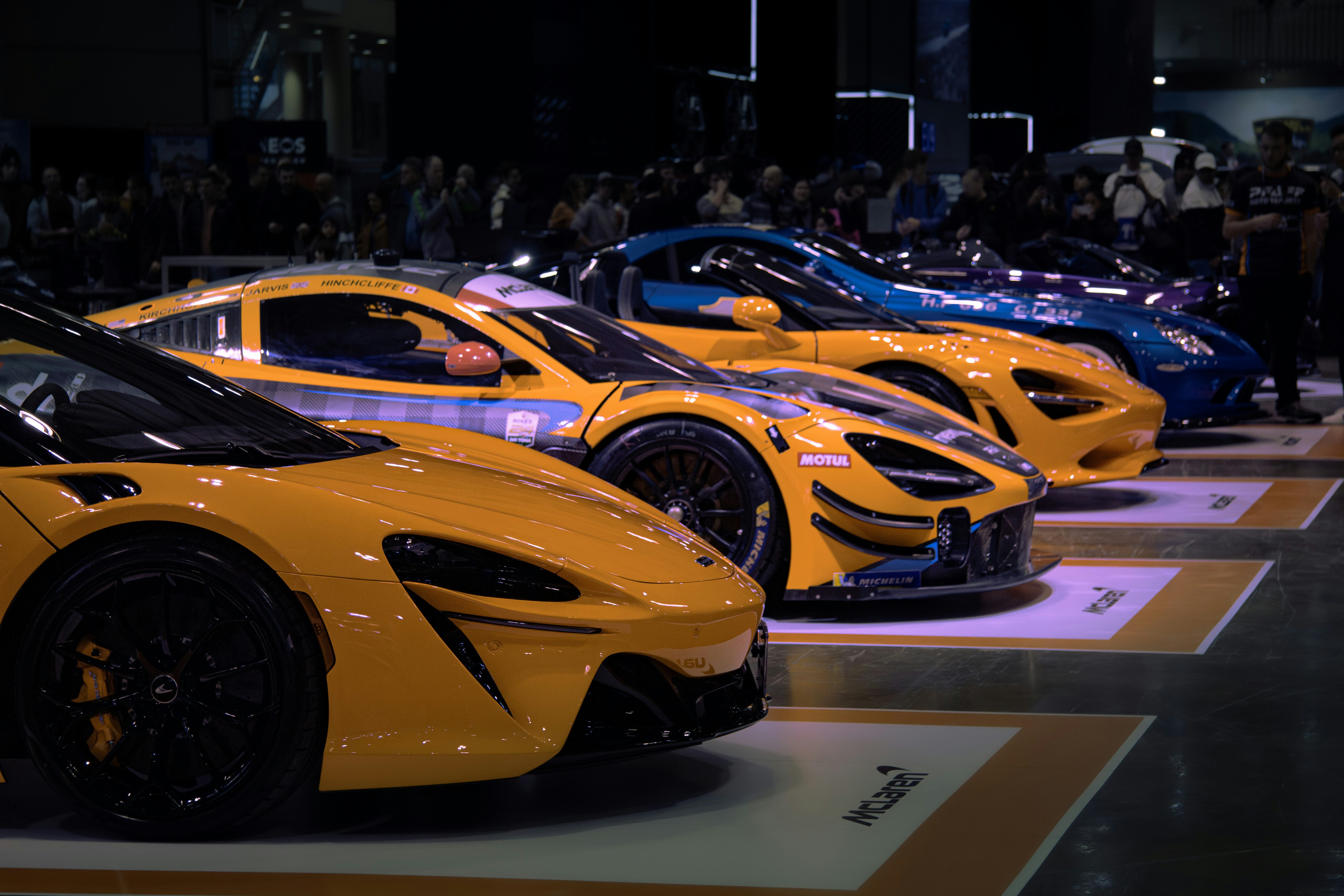 A row of yellow sports cars on display at a car show photo – Free ...