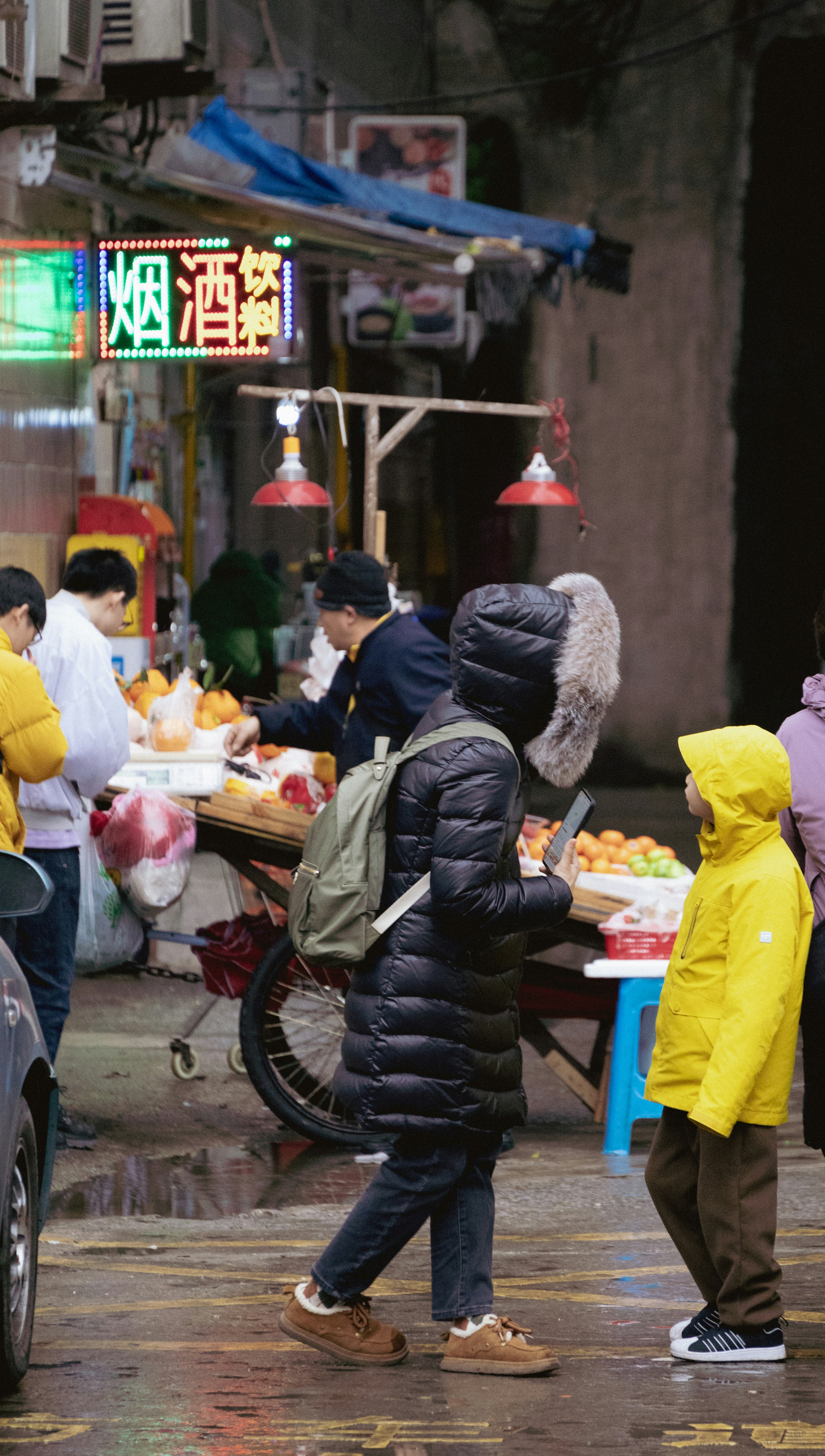 A group of people walking down a rain soaked street photo – Free Chong ...