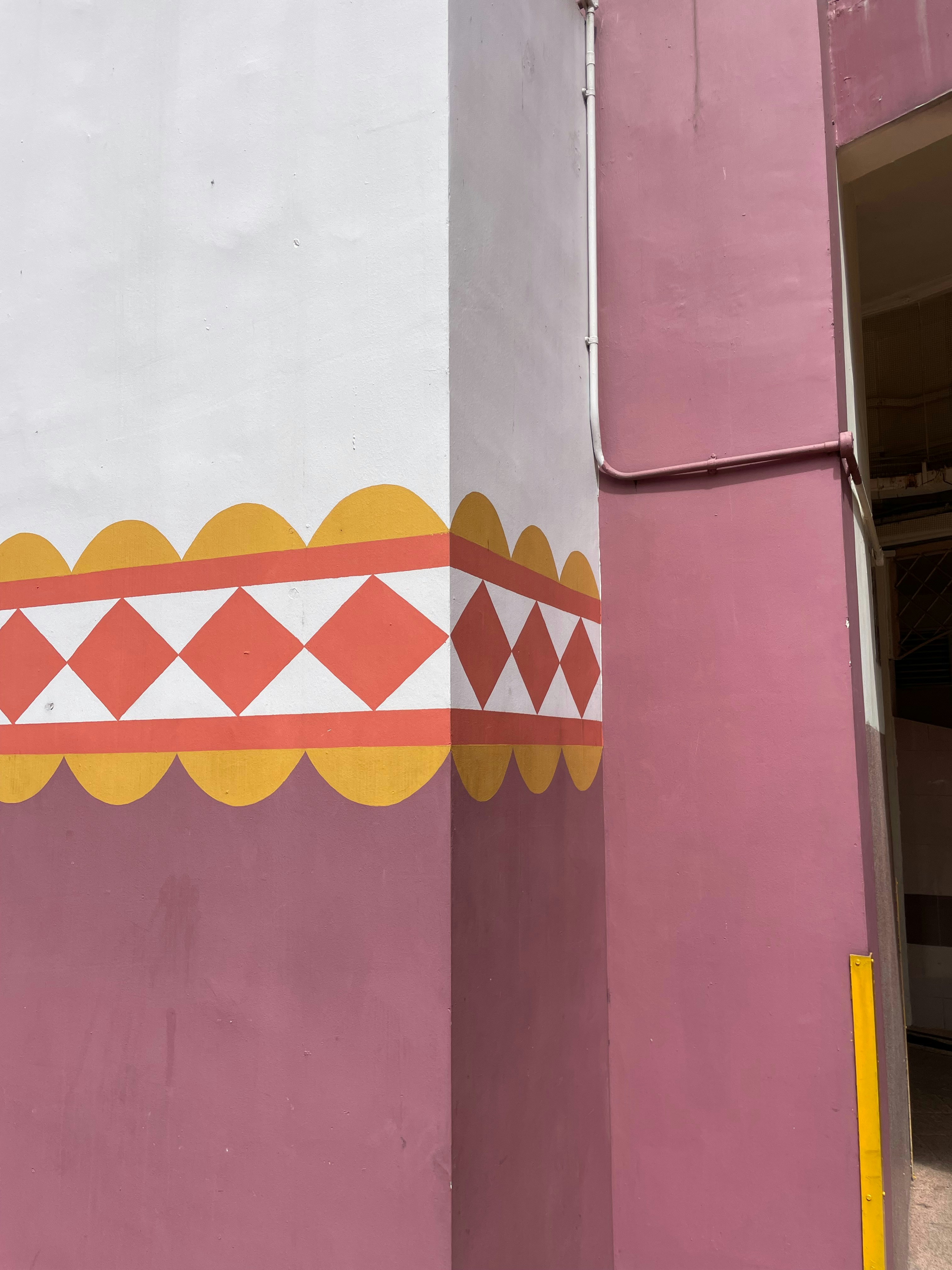 Edge of Color: Diamond-Patterned Ribbon Across a Pink Wall