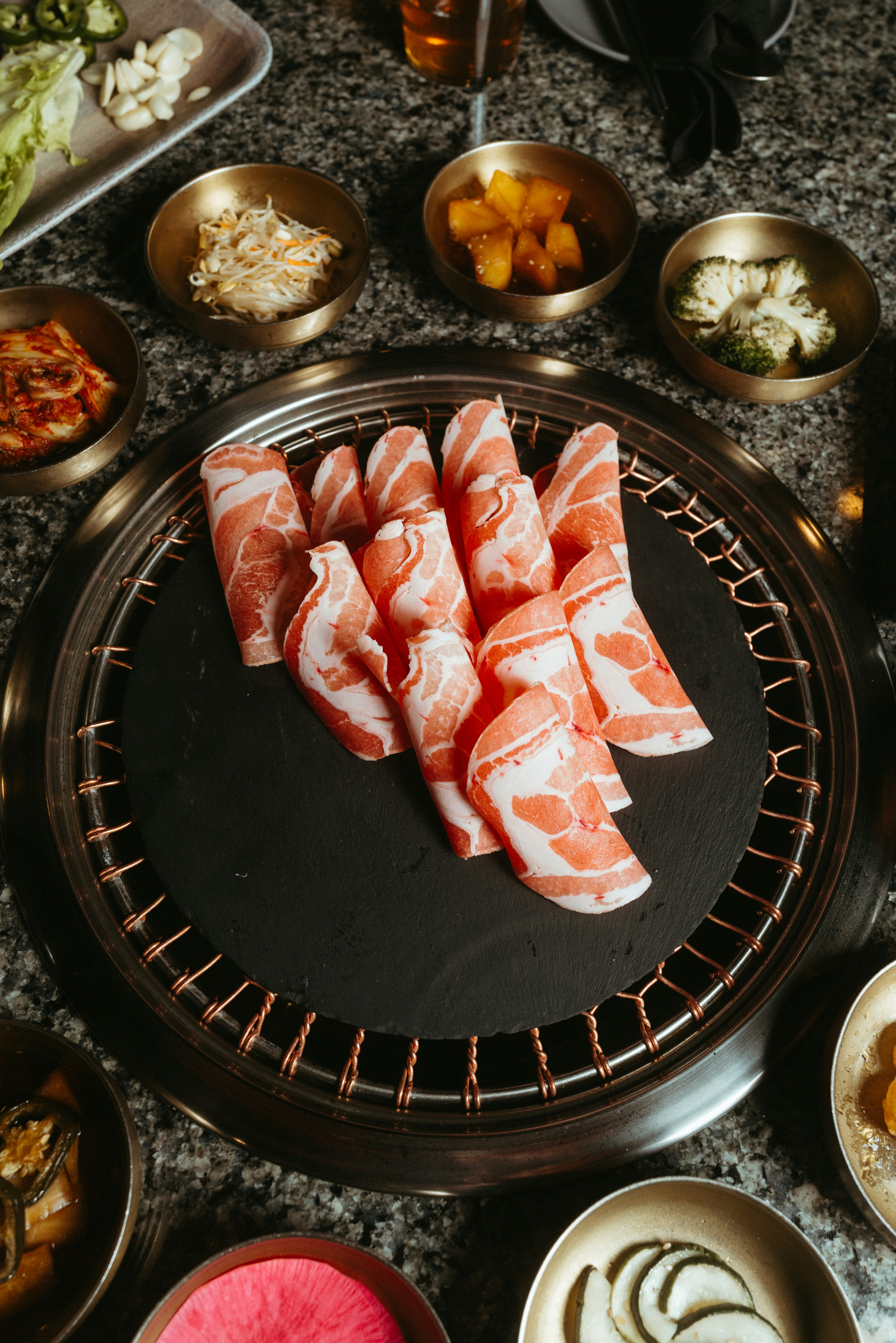 Marbled Pork Belly Rolls Centerstage on a Circular Korean BBQ Grill