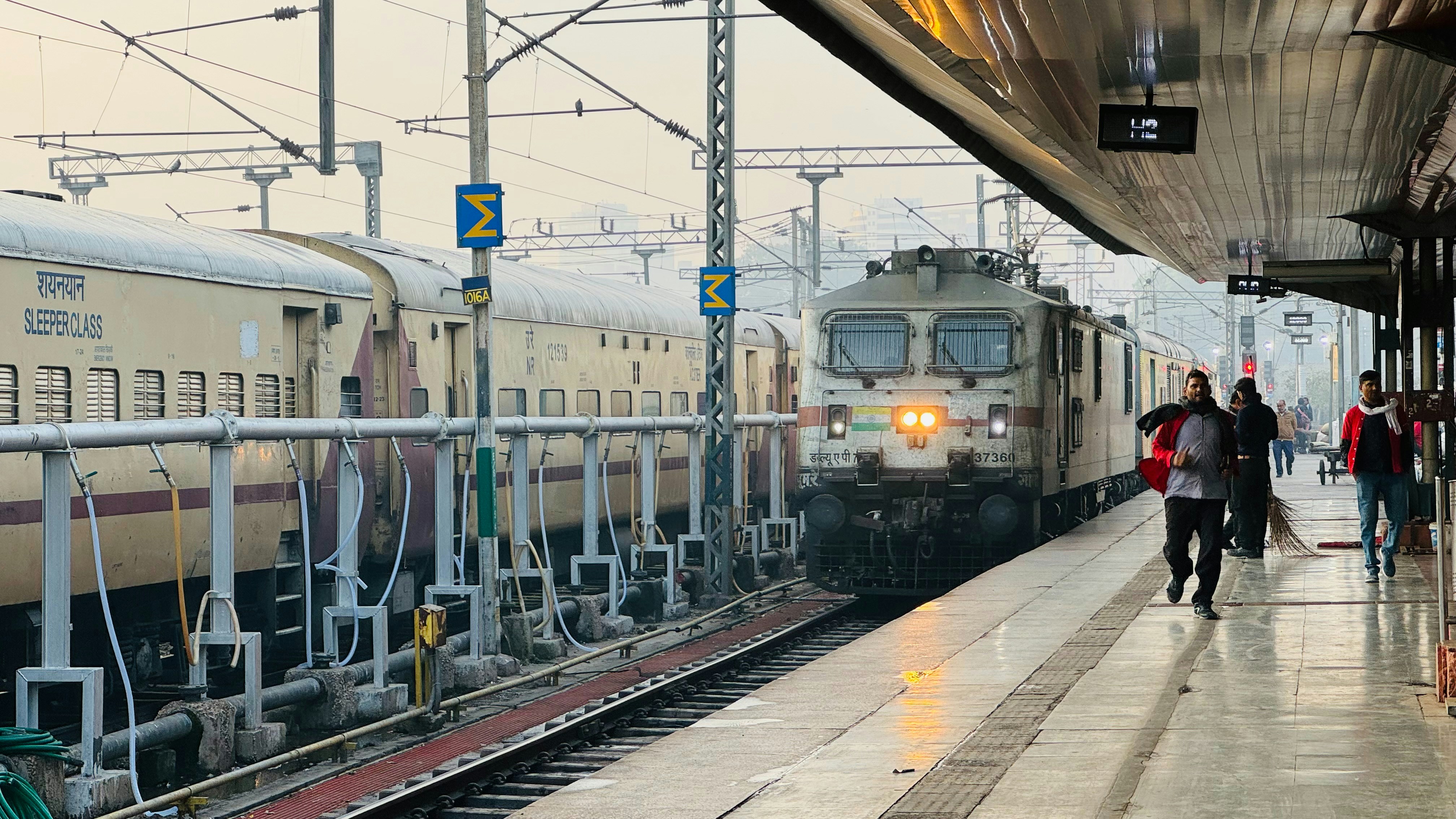 A train pulling into a train station next to a platform photo – Free ...