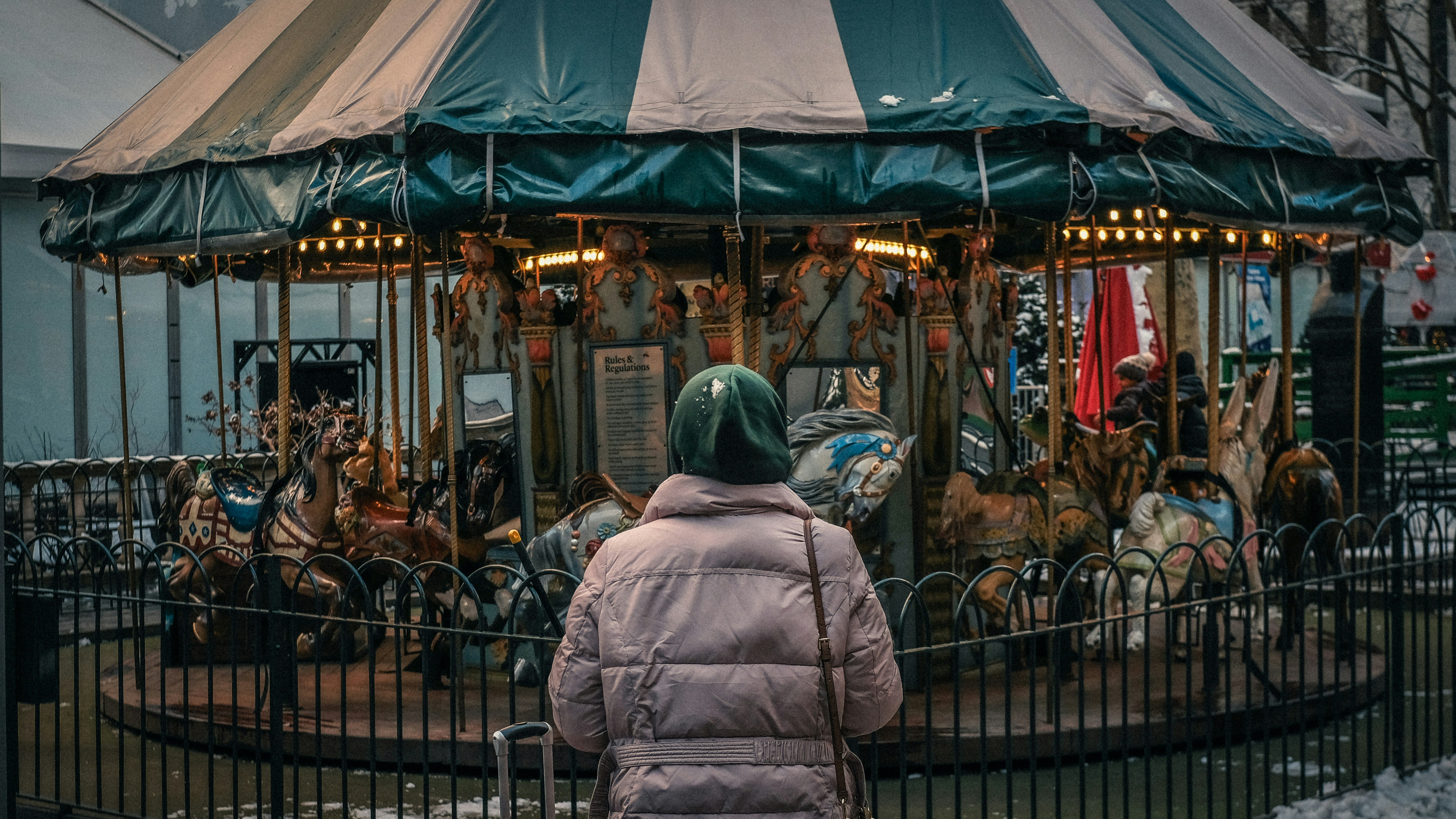 A person standing in front of a merry go round photo – Free Carousel ...