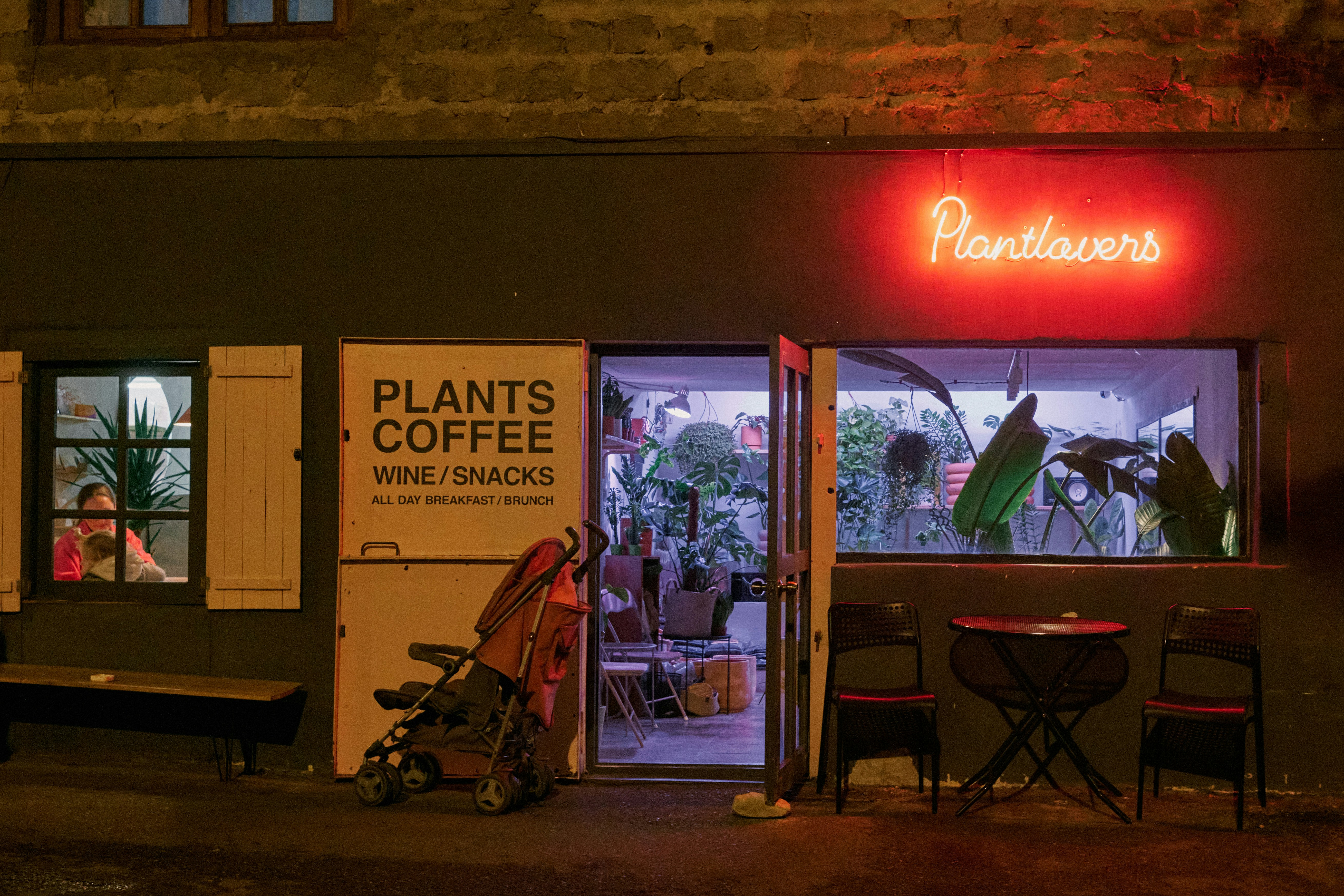 A restaurant with a neon sign and a stroller outside photo – Free ...
