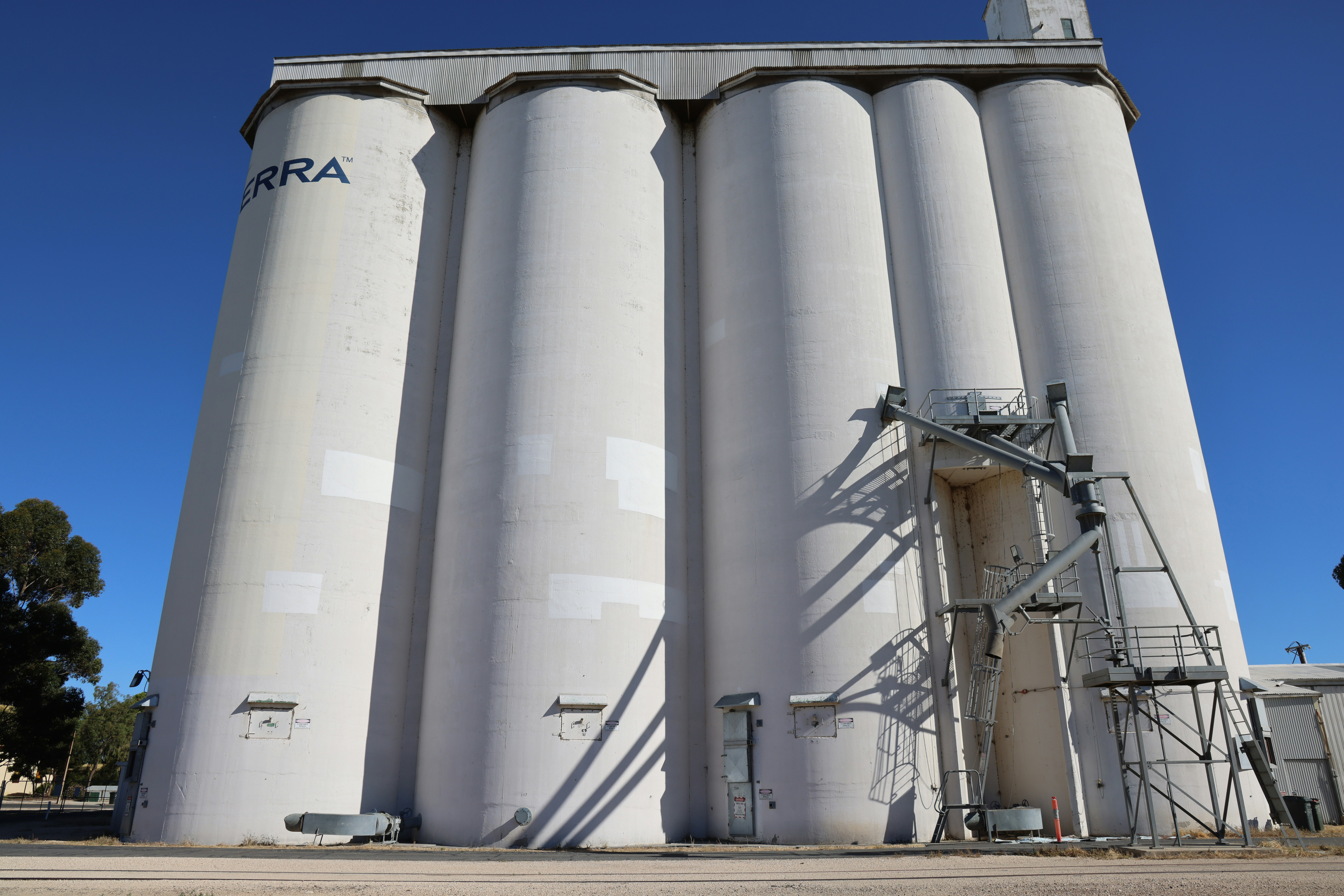 Silo in Lameroo, South Australia. | a large white silo sitting next to a tall building