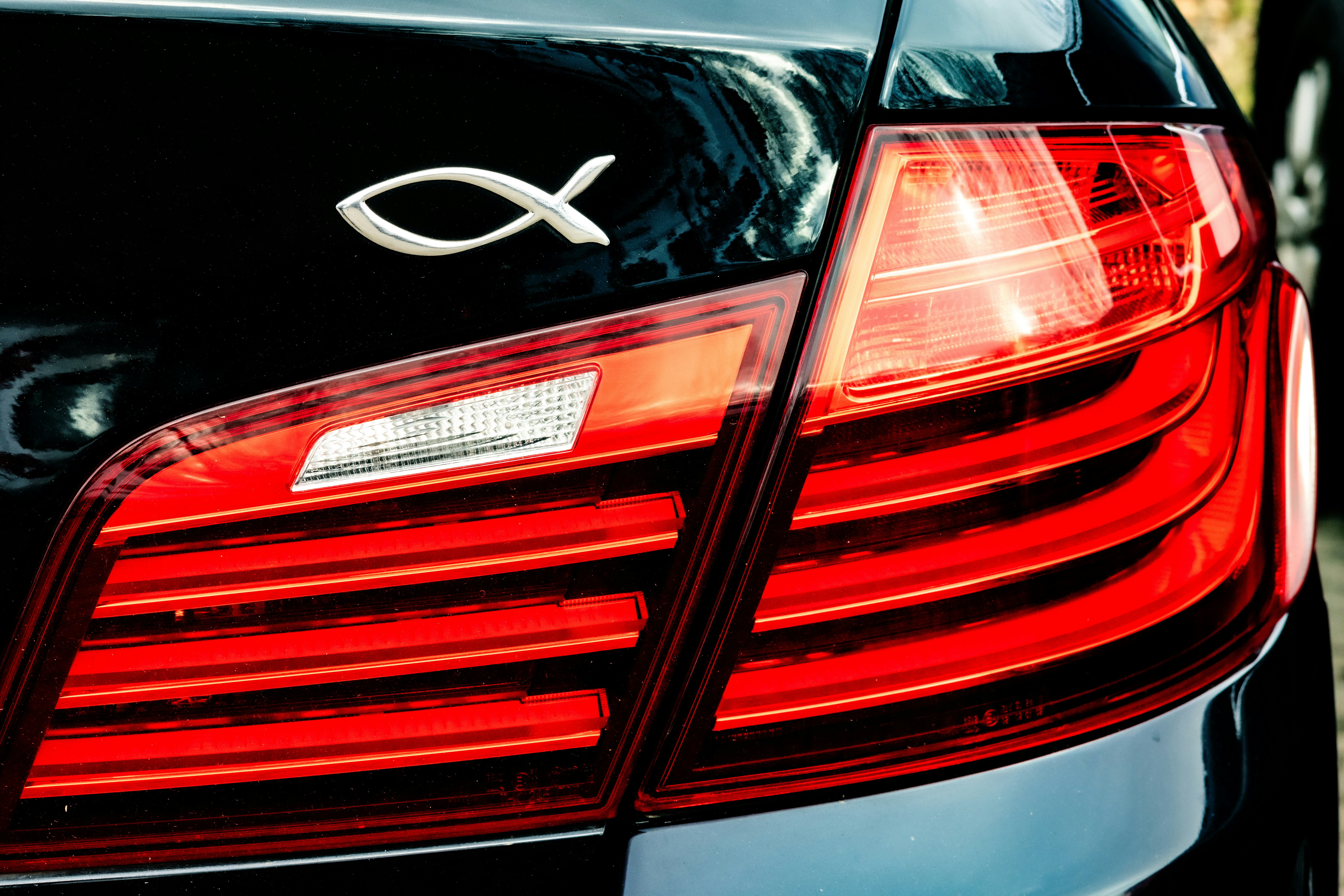 Infinity Emblem in Red: Tail-Light Geometry on a Glossy Black Finish