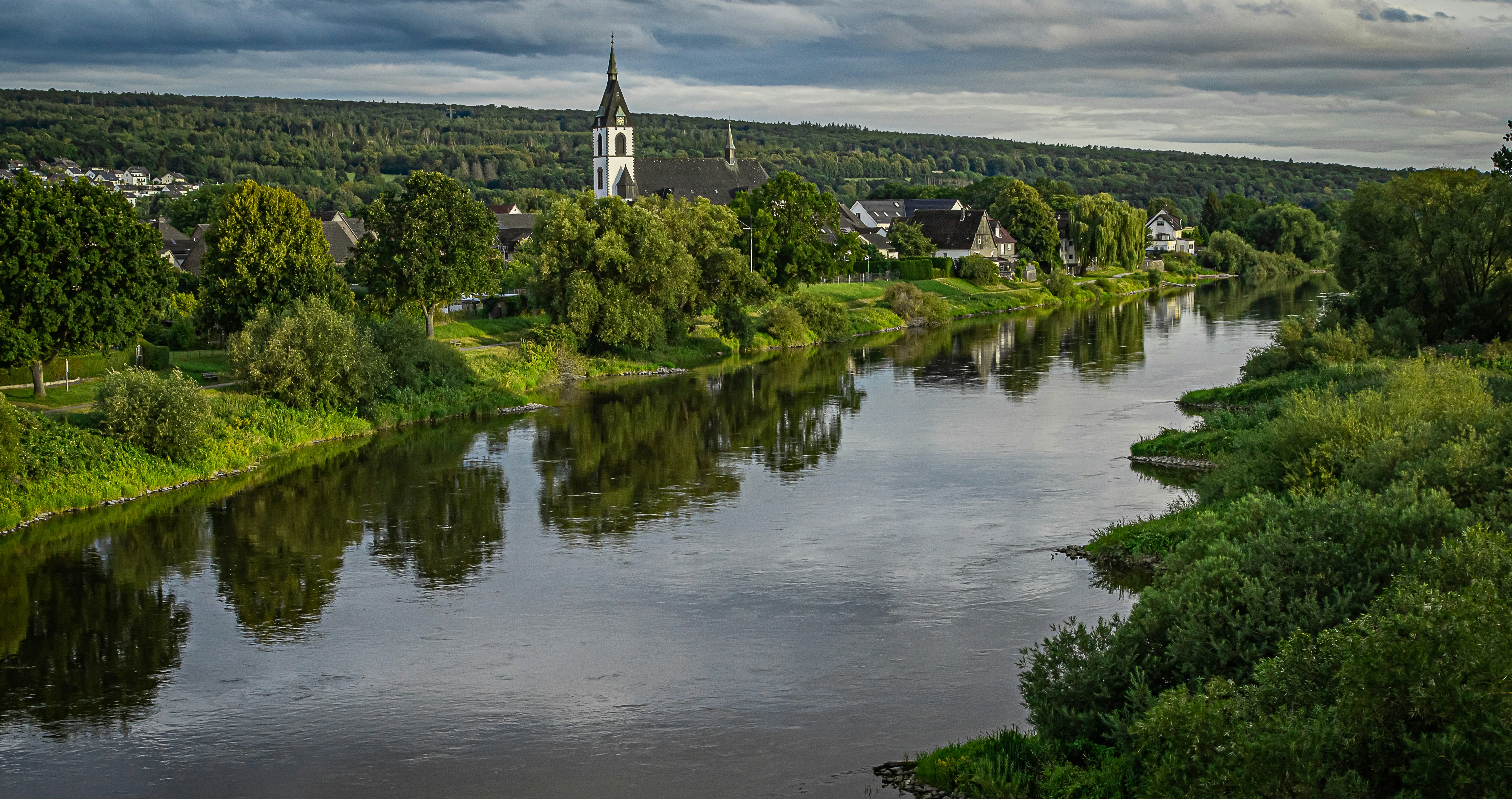 Riverbend Village: A Church Tower Quietly Reaches Toward a Brooding Sky