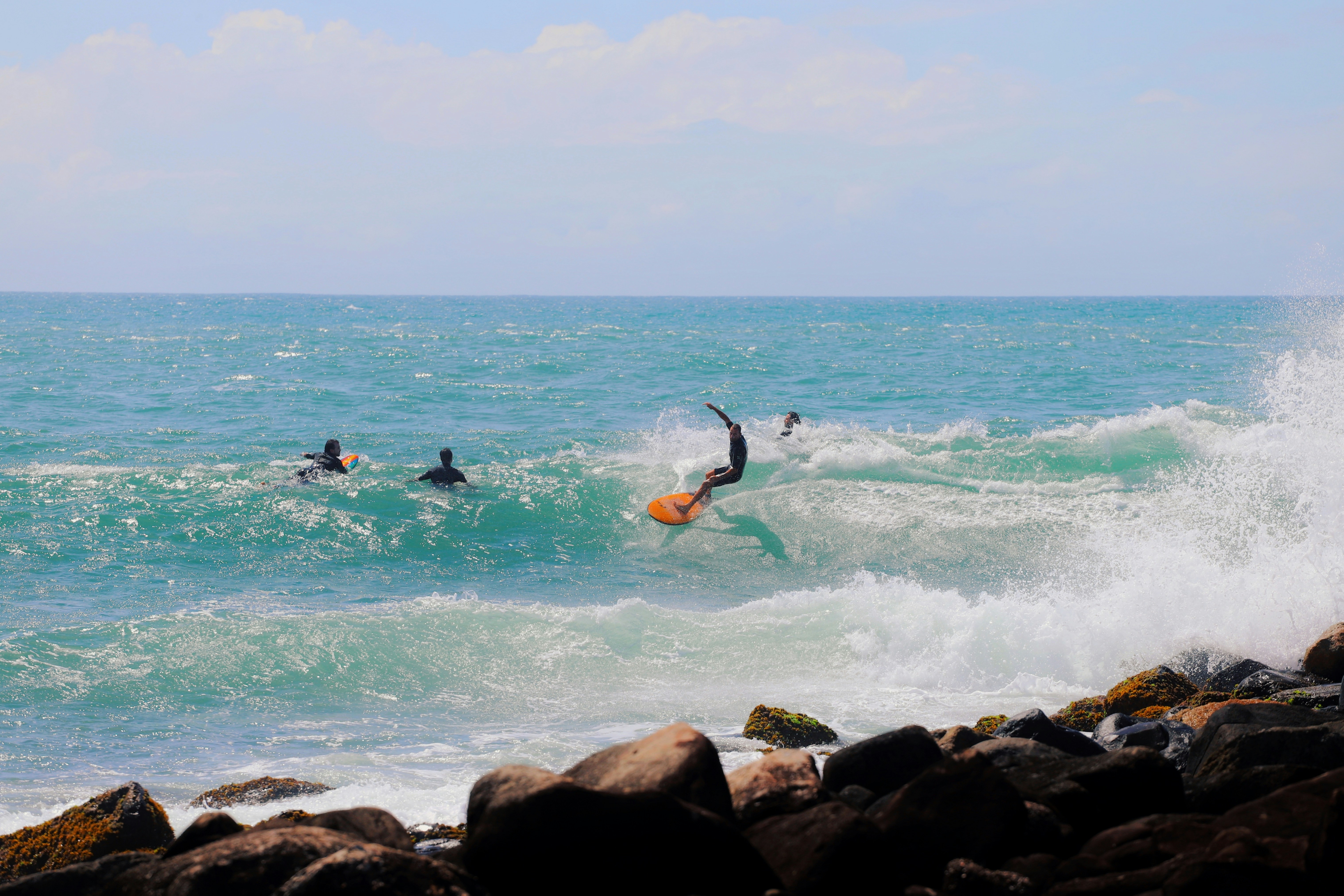A group of people riding waves on top of surfboards photo – Free Blue ...