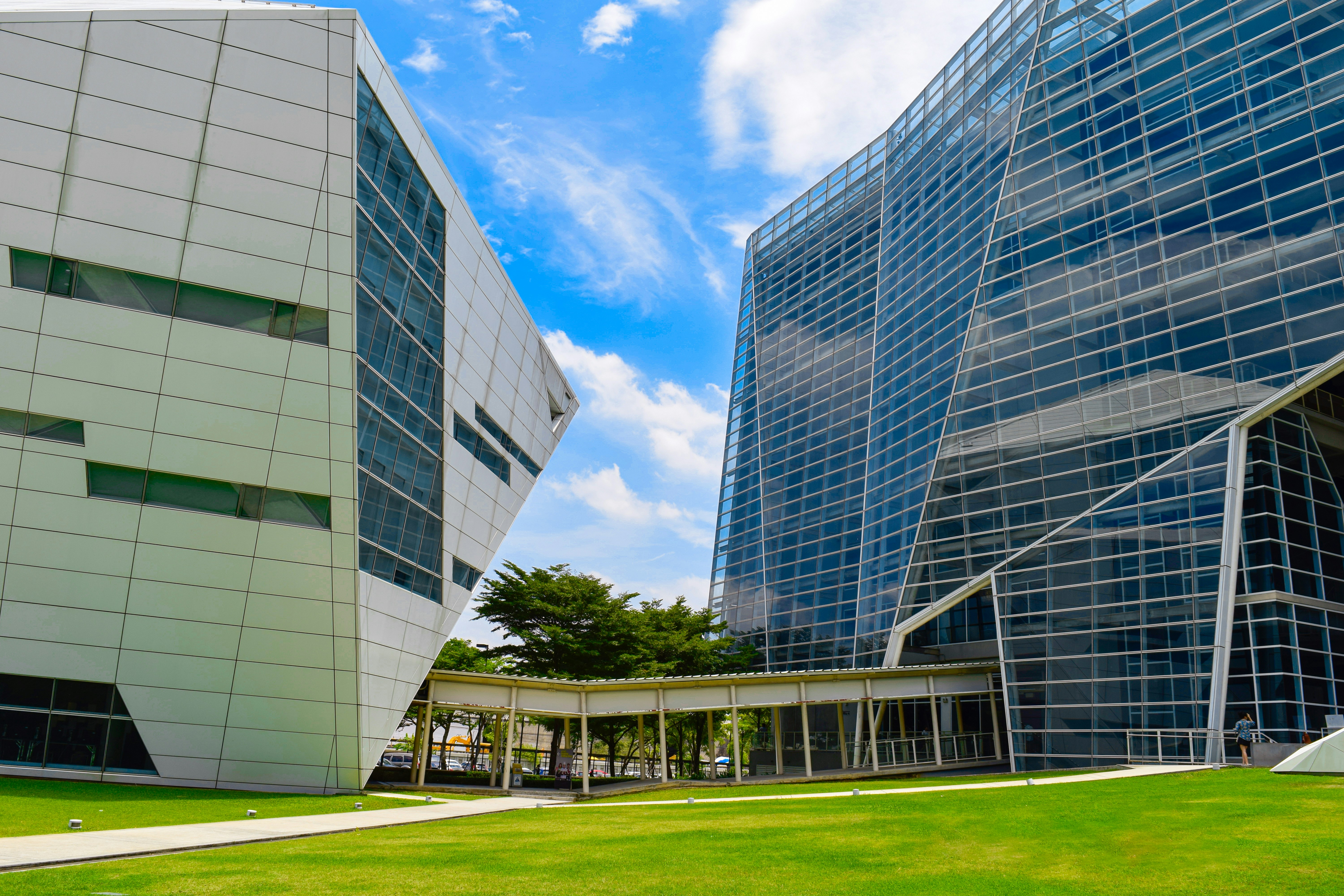Contemporary architectural structures with glass facades under a bright blue sky.
