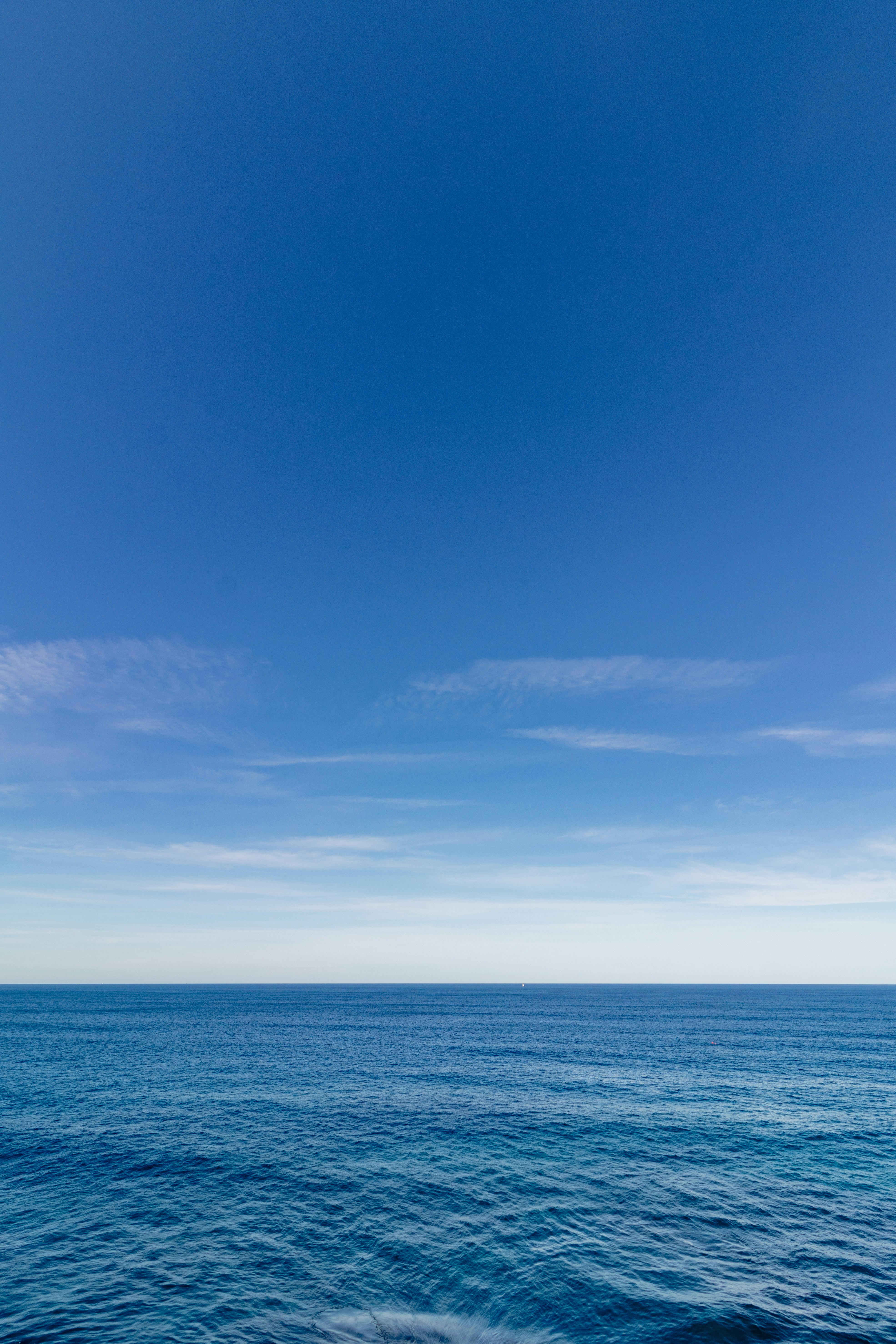 a large body of water sitting under a blue sky