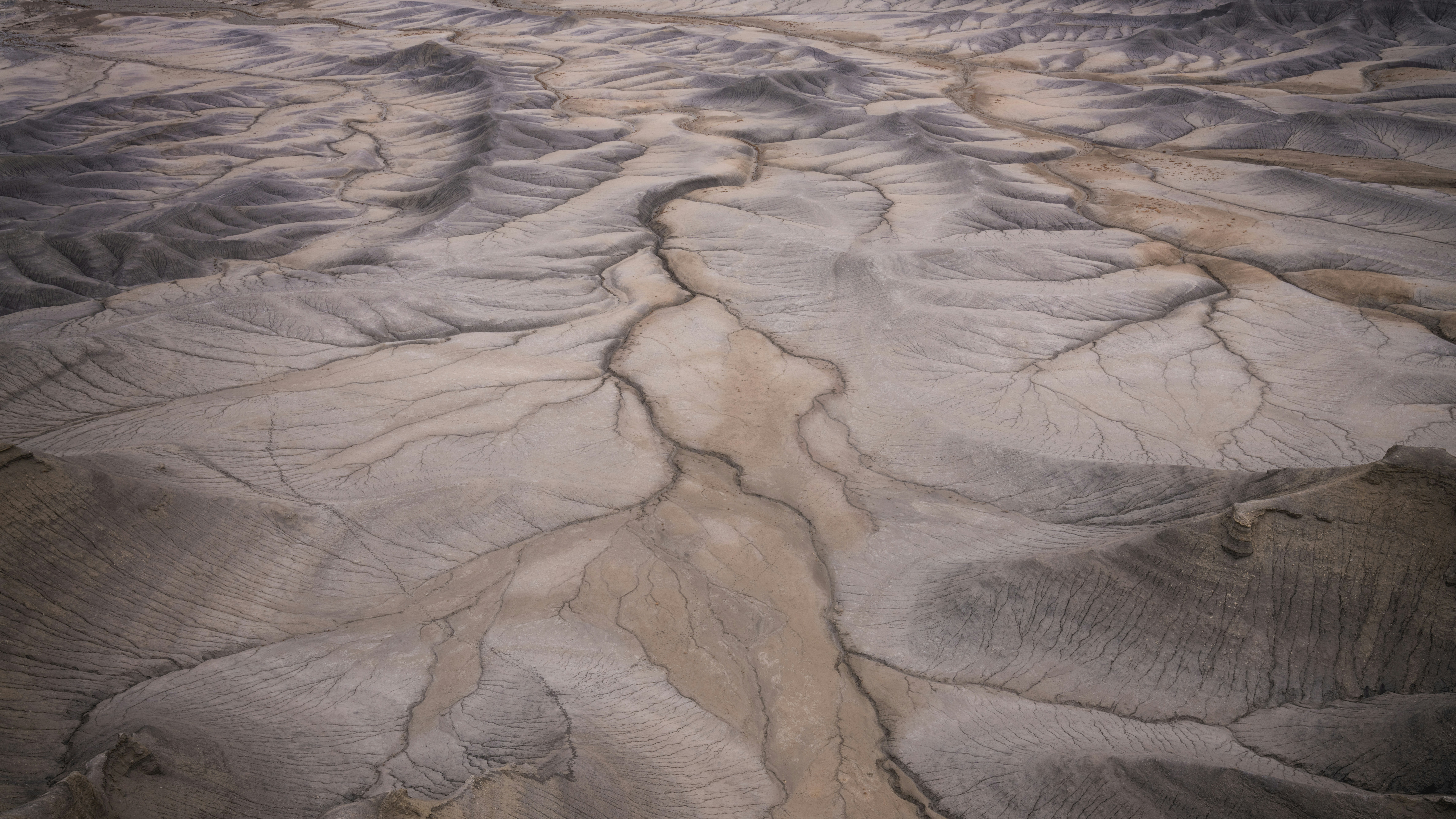 An aerial view of a desert landscape with mountains in the background ...