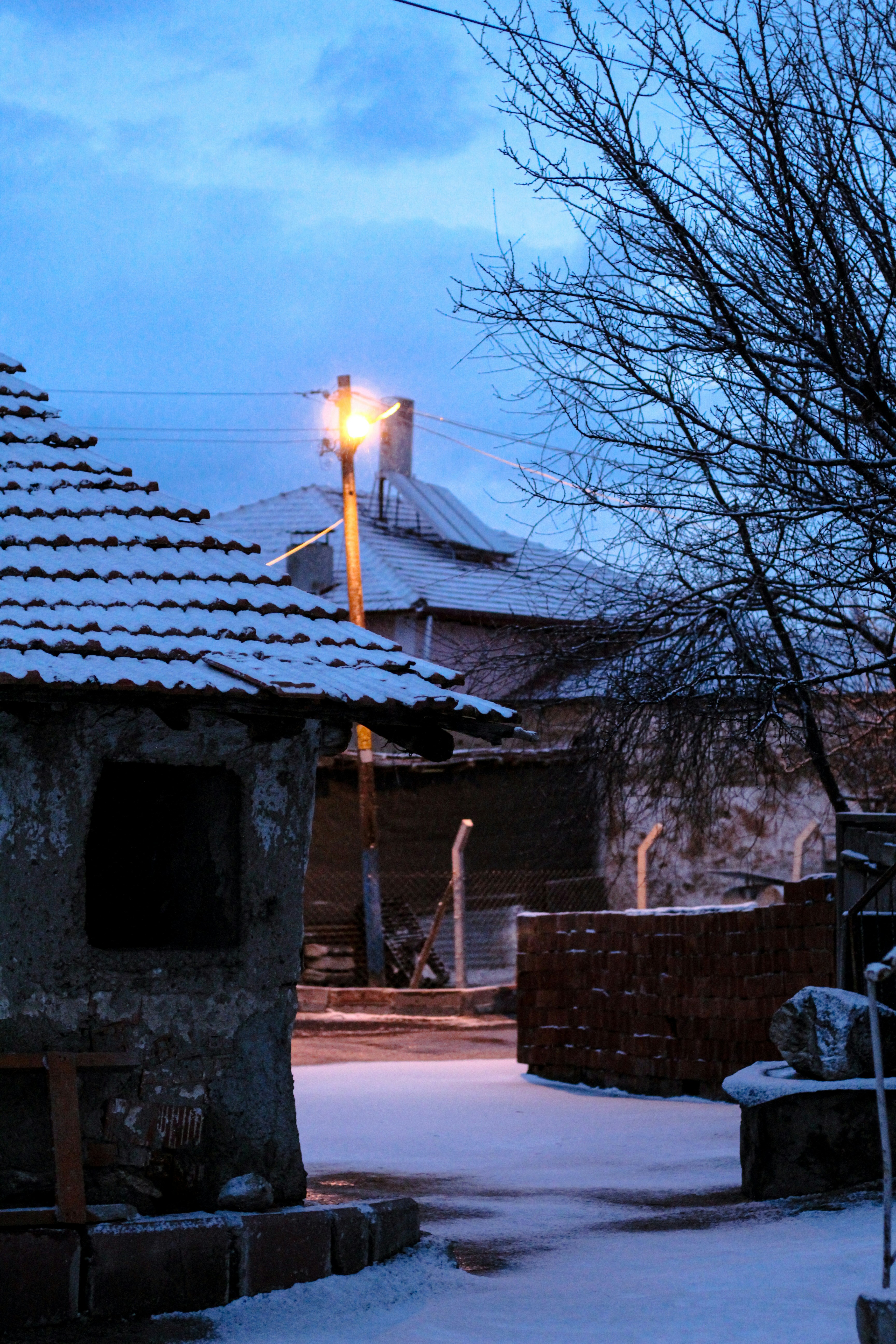 Blue Hour Lantern over a Snow-Dusted Village Lane
