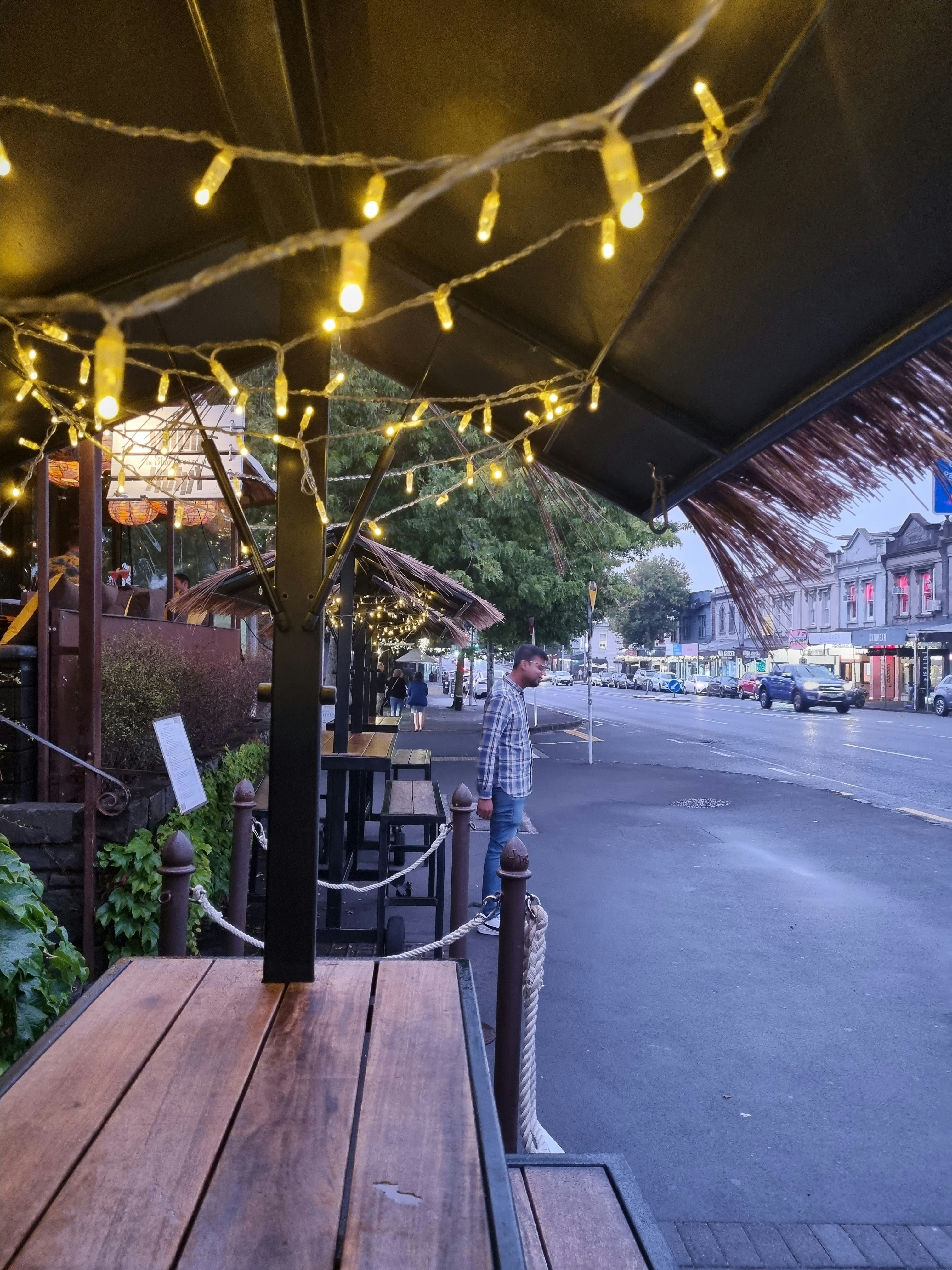 a man standing on a wooden deck next to a street