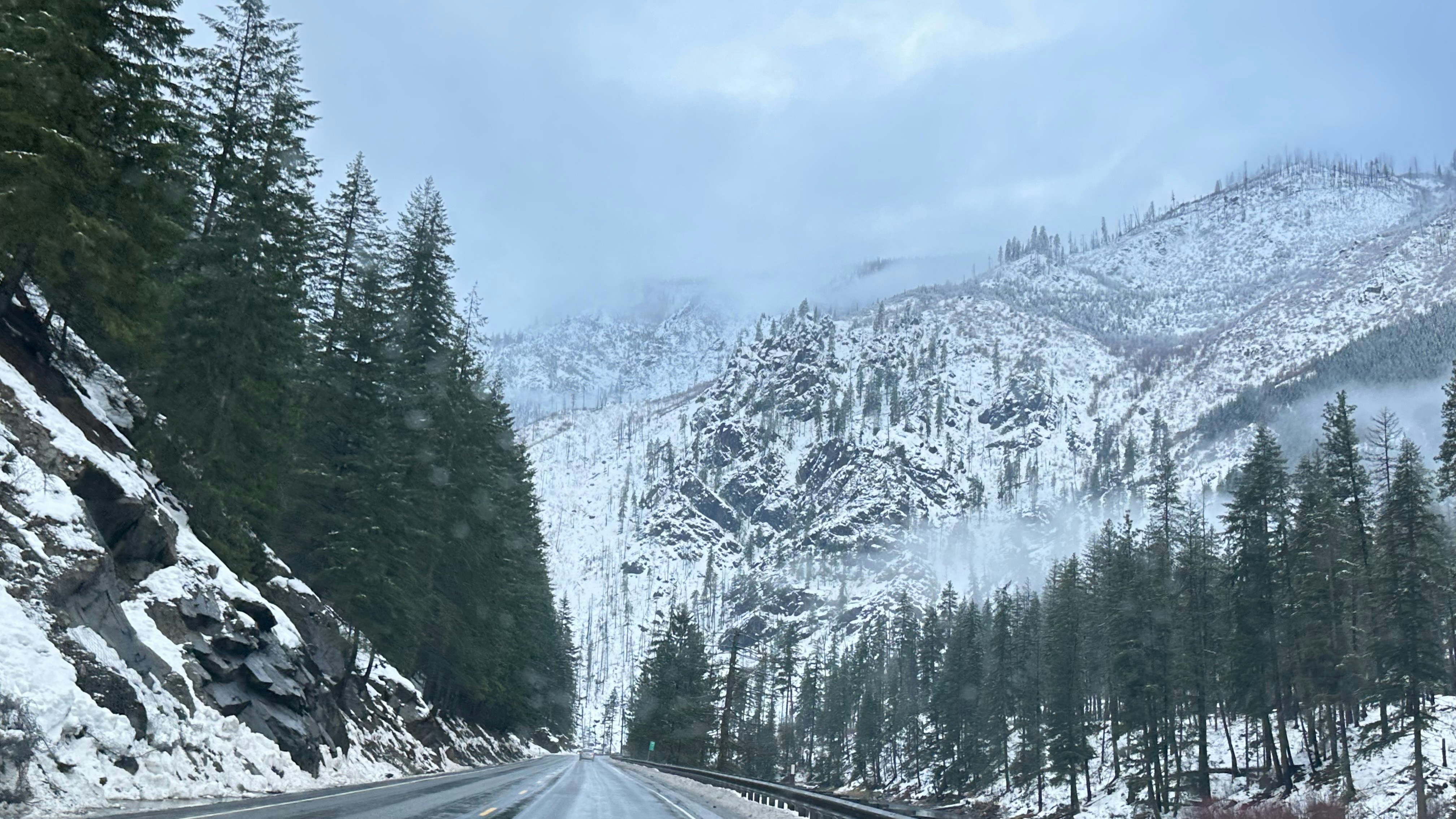 Snowbound Highway Toward a Mist-Laced Alpine Ridge
