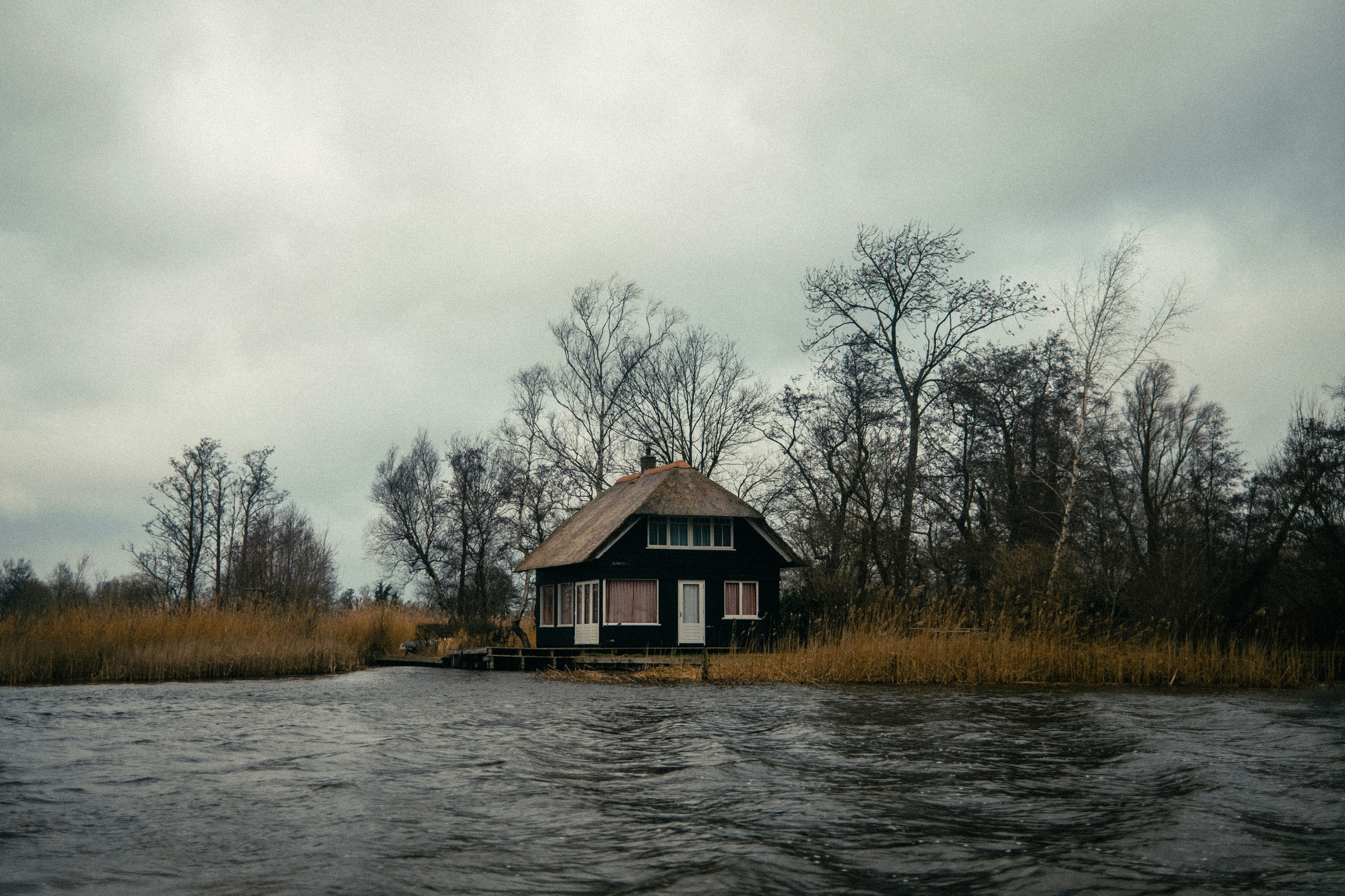 A house sitting on the edge of a body of water photo – Free House Image ...