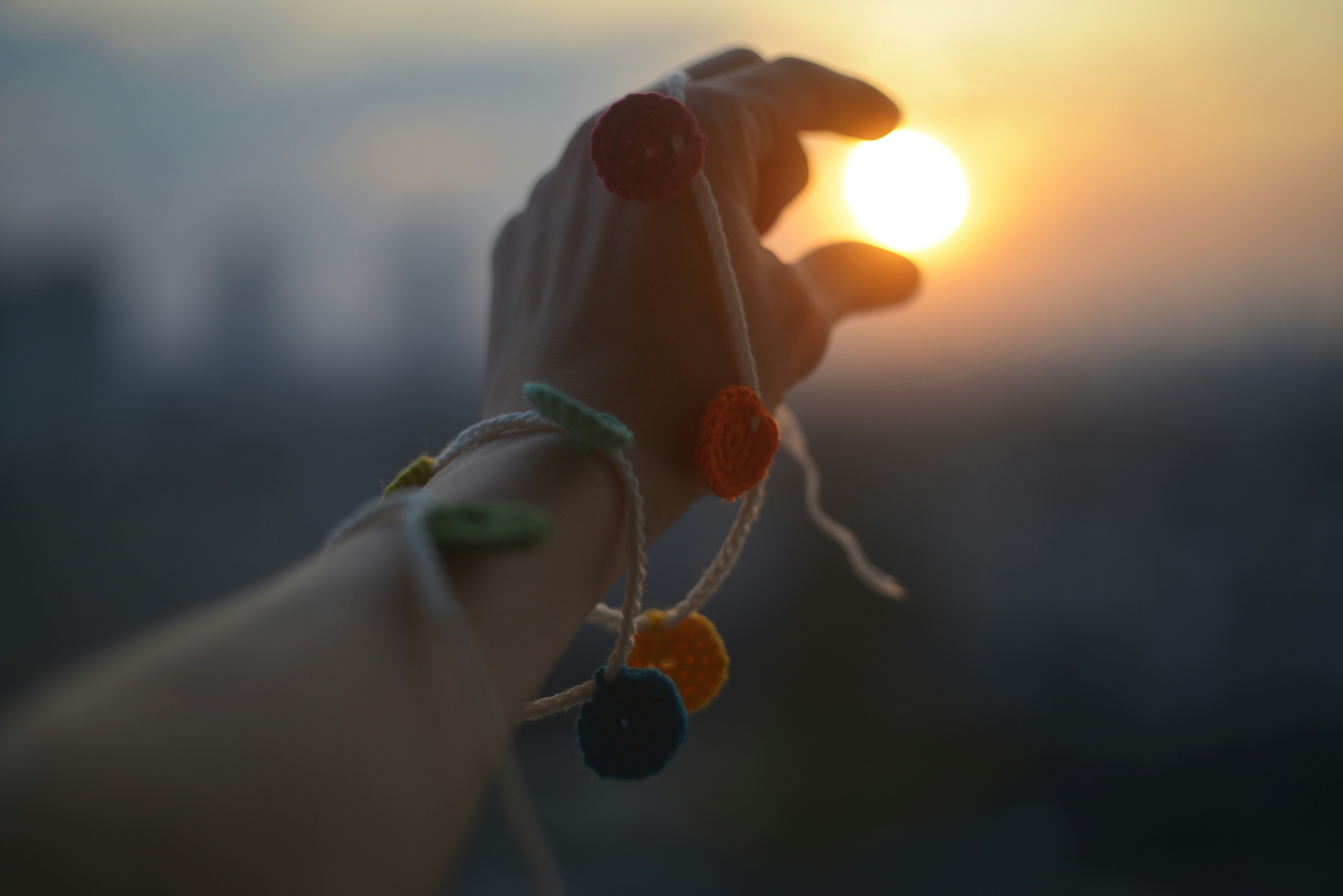Sunlit Dangle: A Hand Reaches Toward the Rising Light
